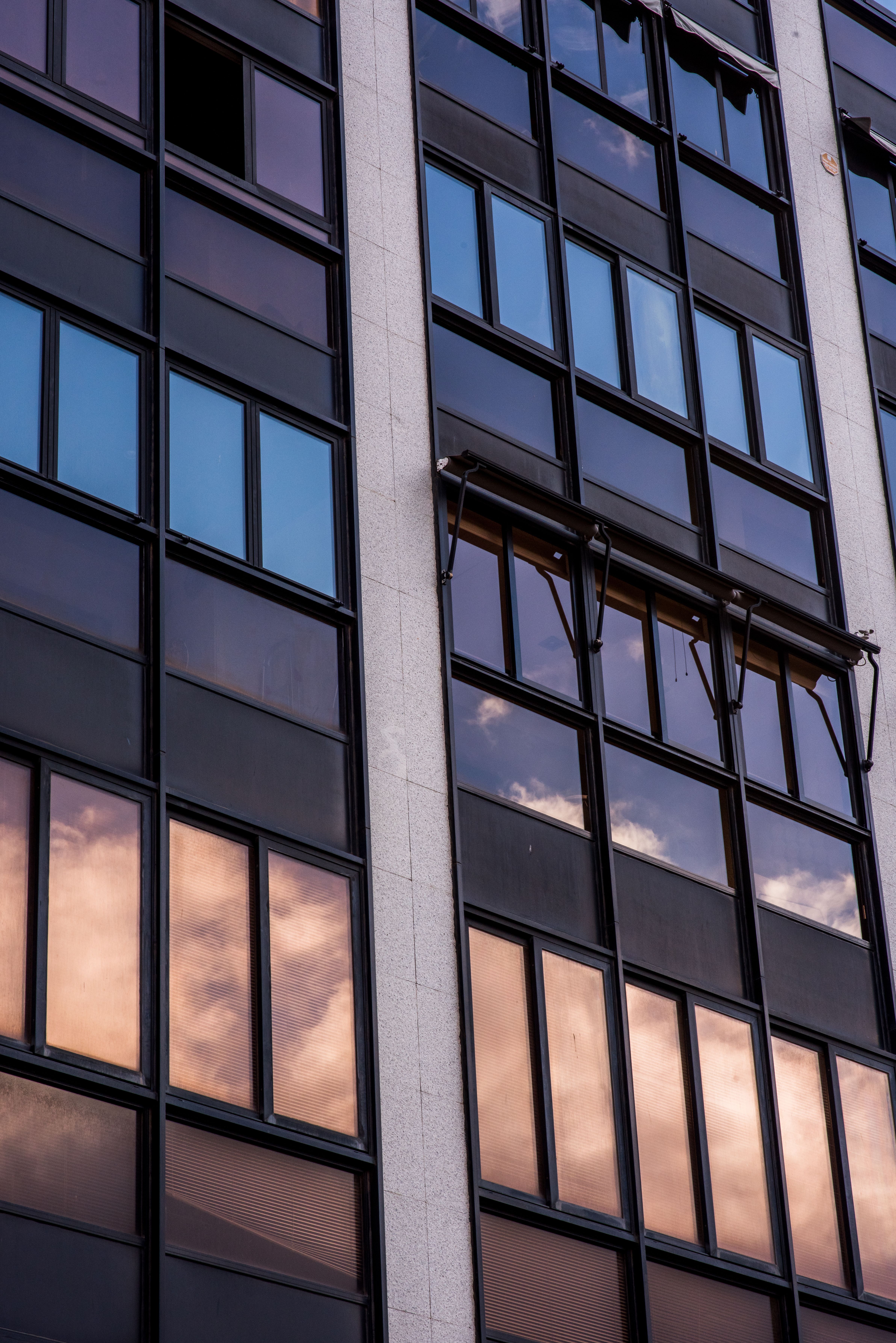 Modern Building Windows Reflecting Sunset Clouds · Free Stock Photo