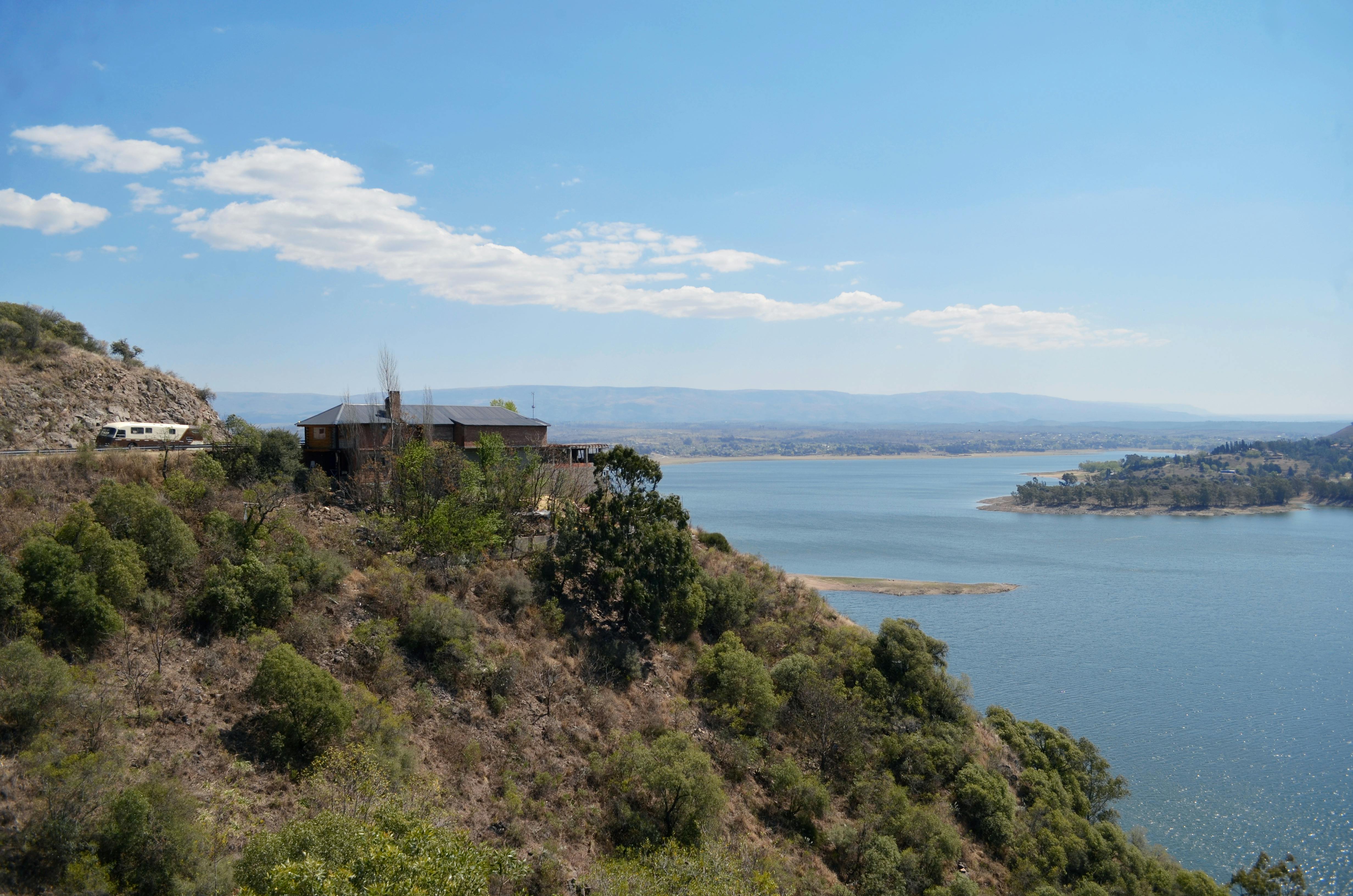 Scenic View of House on Lakeside Cliff · Free Stock Photo
