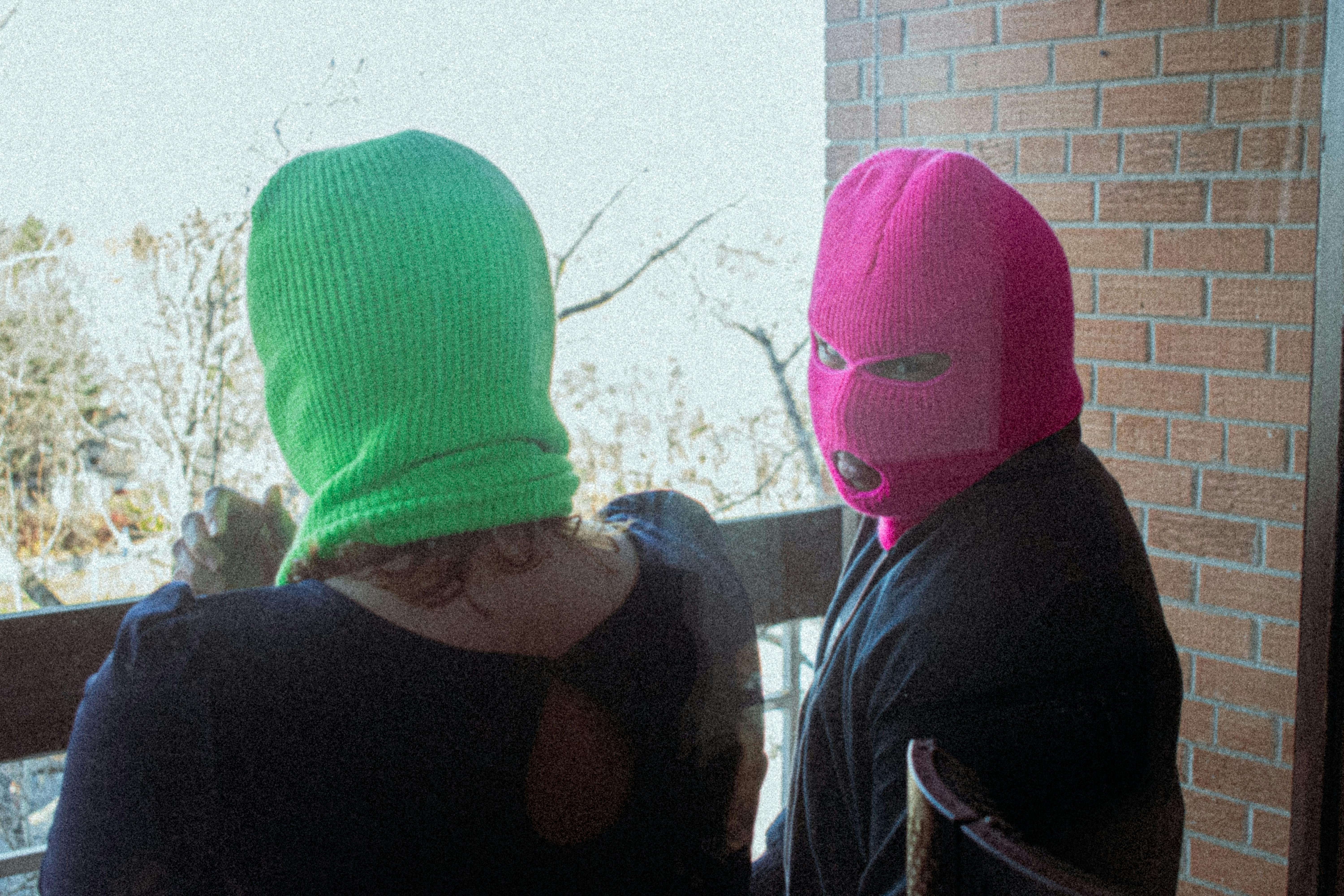 Two People in Colored Ski Masks on Balcony · Free Stock Photo