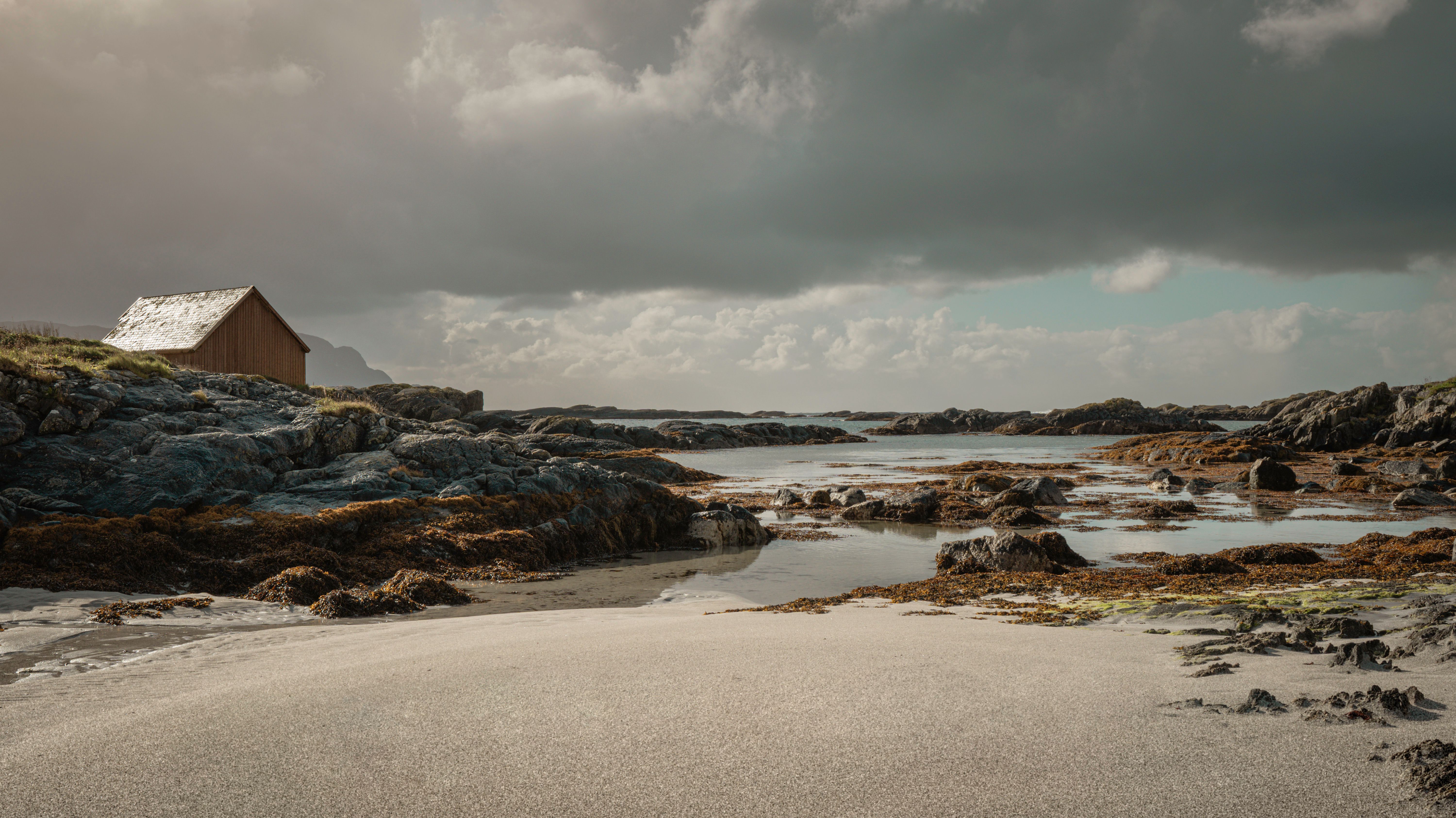 Rustic Coastal Hut on a Rocky Shoreline · Free Stock Photo