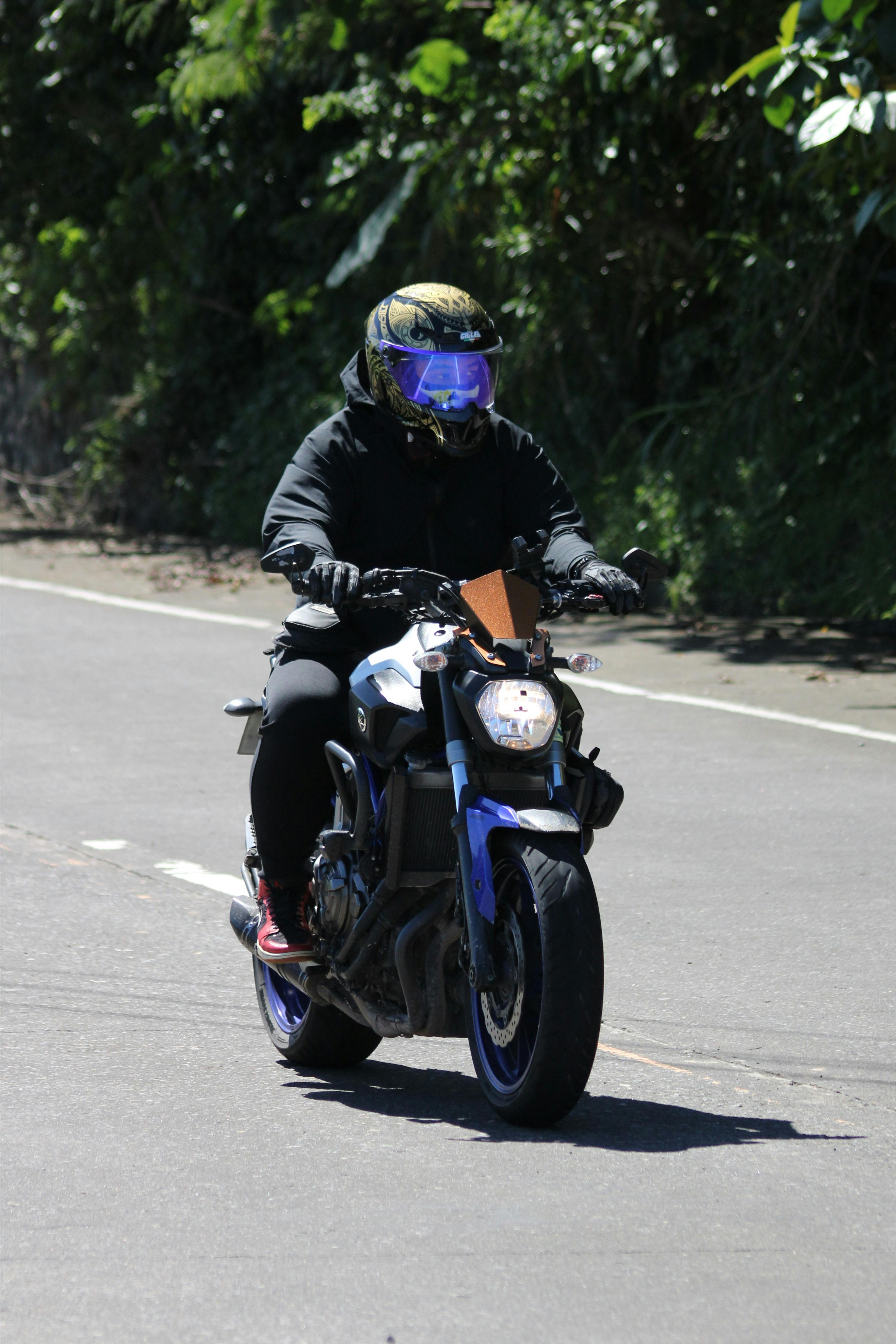 Photo of a Person with a Red Helmet Riding a Motorcycle · Free Stock Photo