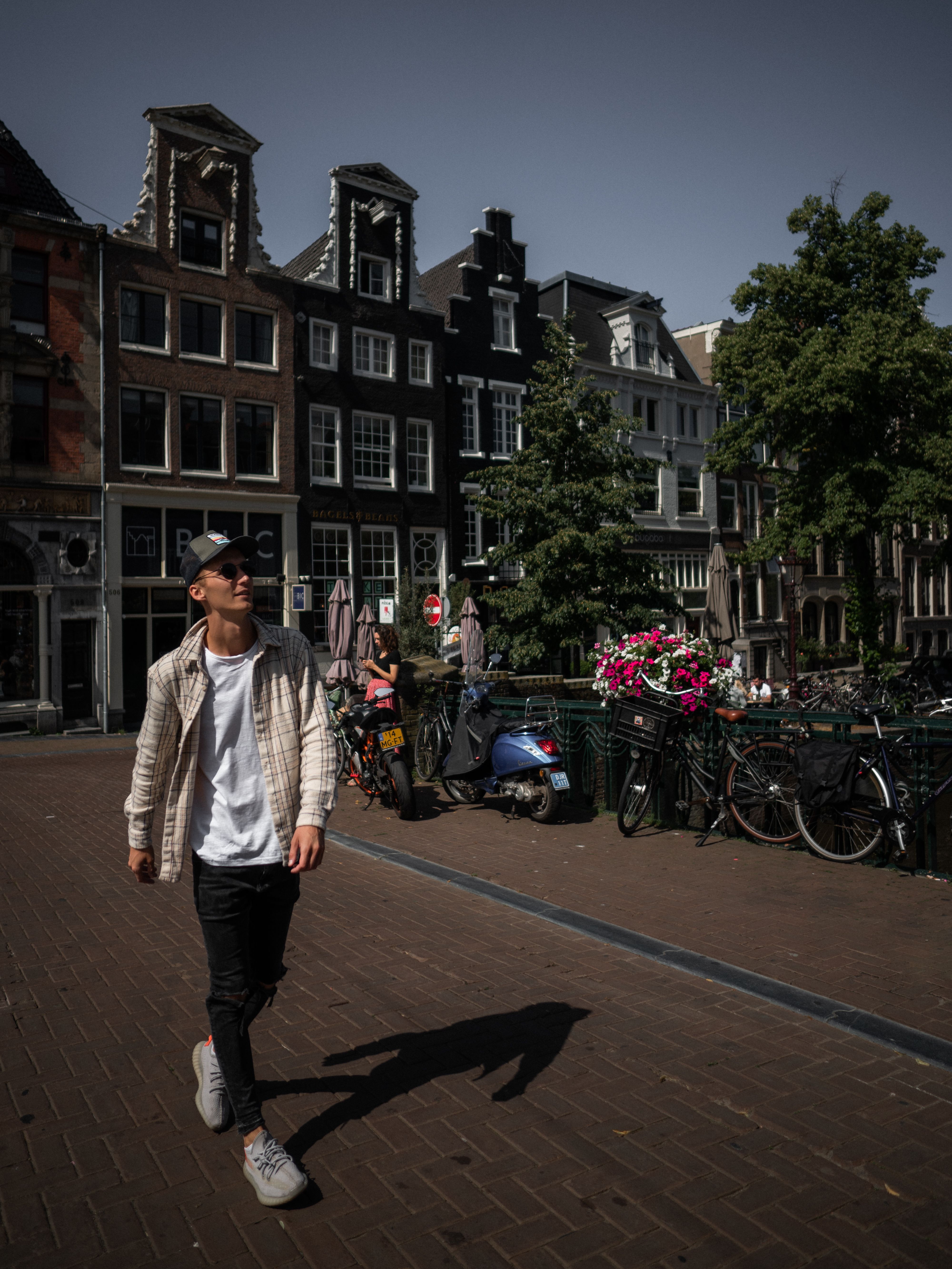 Man Walking in Sunny Amsterdam Street Scene · Free Stock Photo