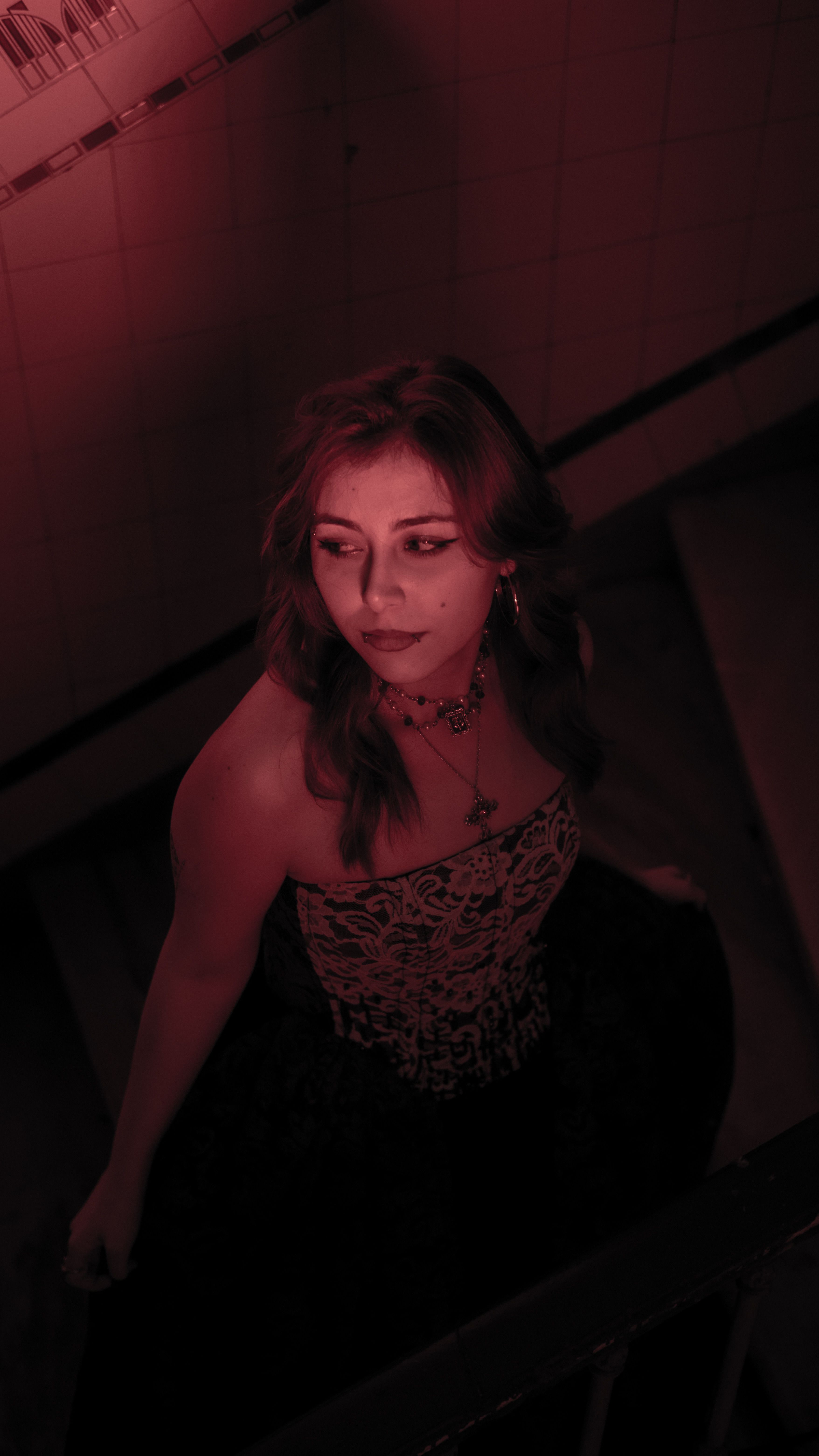 Moody Portrait of Woman in Dimly Lit Stairwell · Free Stock Photo