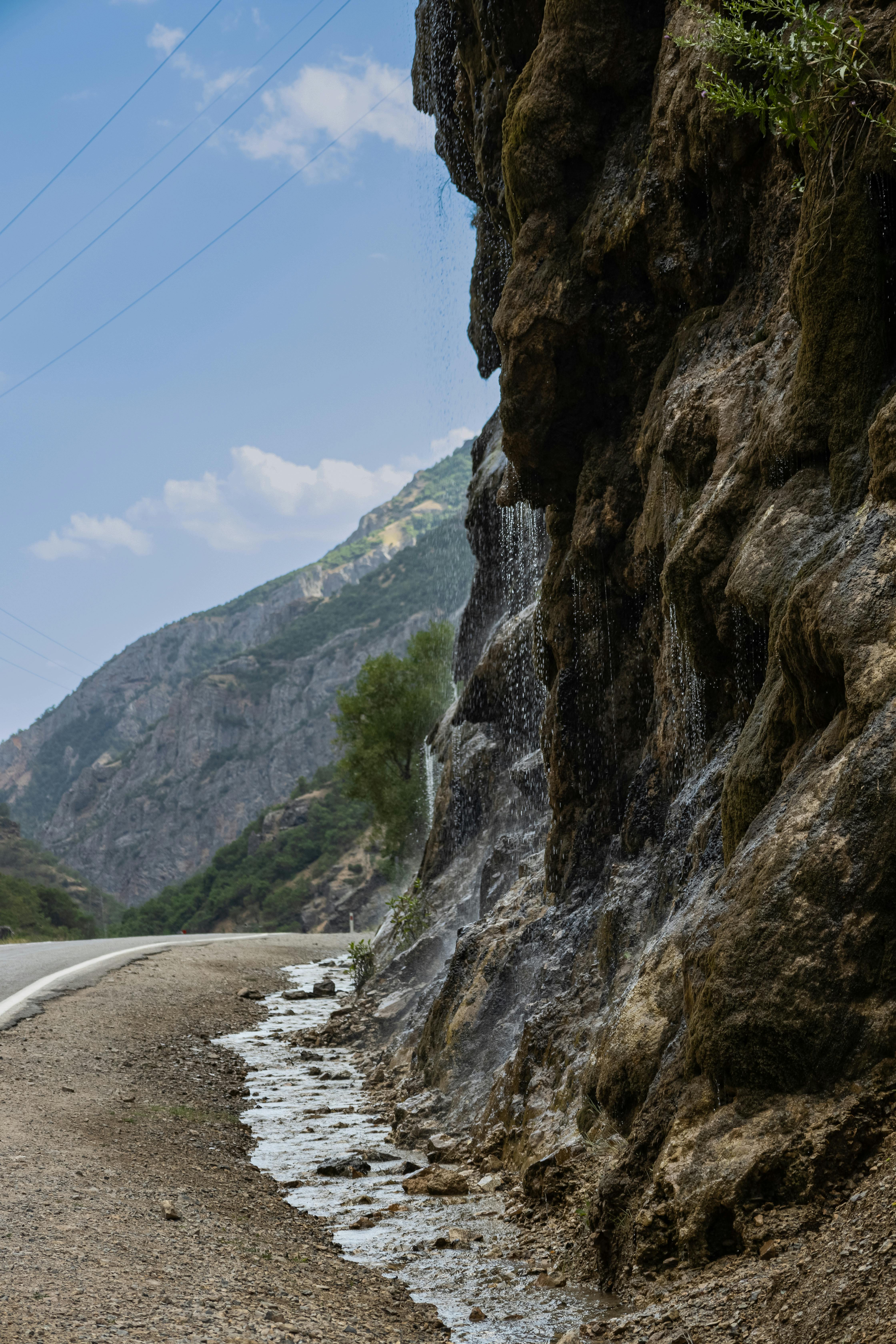 Scenic Mountainside Road with Natural Waterfall · Free Stock Photo