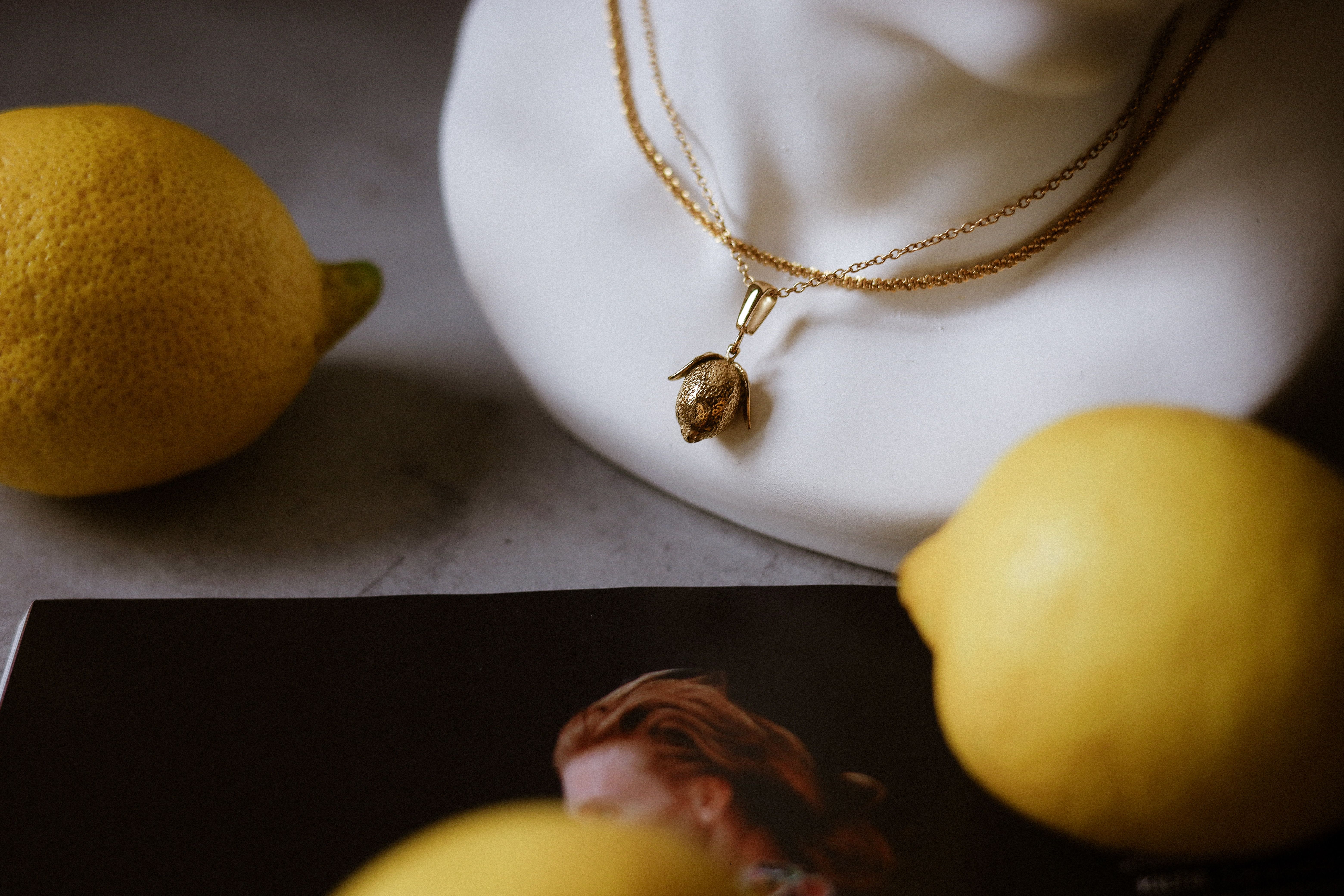 Elegant Gold Necklace with Lemon Pendant Display · Free Stock Photo