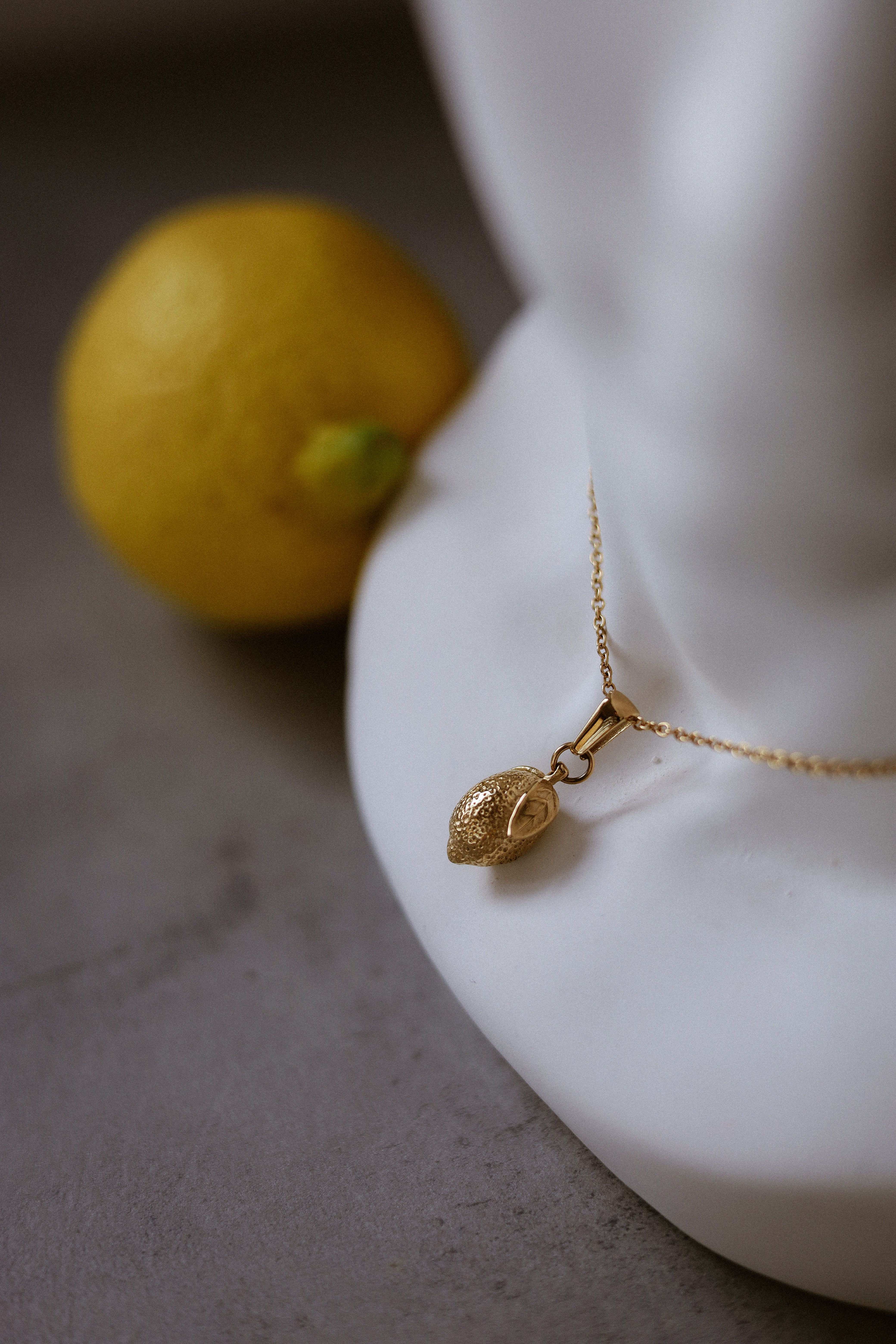 Minimalist Gold Lemon Pendant with Yellow Lemon · Free Stock Photo