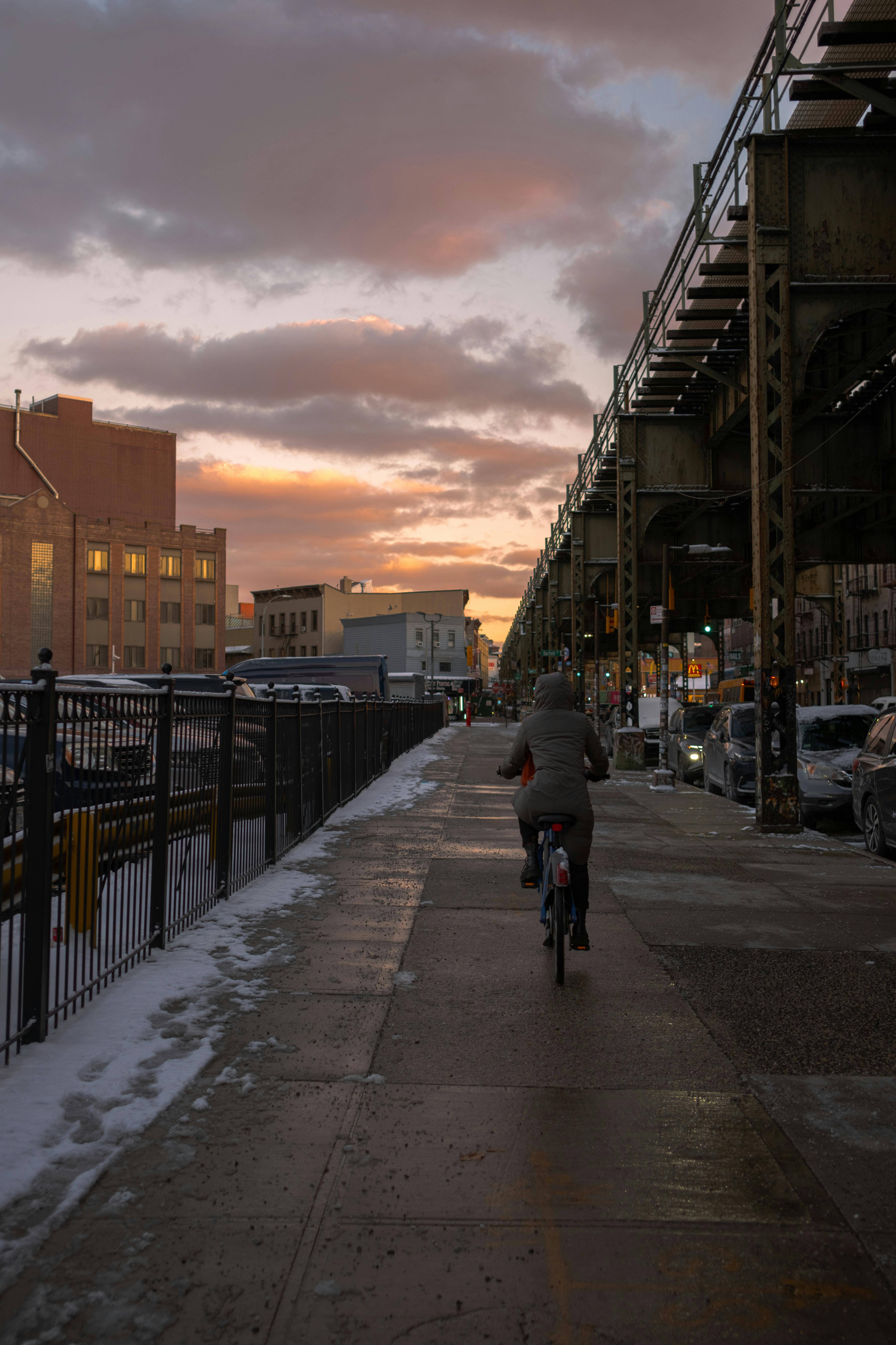 Cyclist on Urban Sidewalk at Sunset · Free Stock Photo