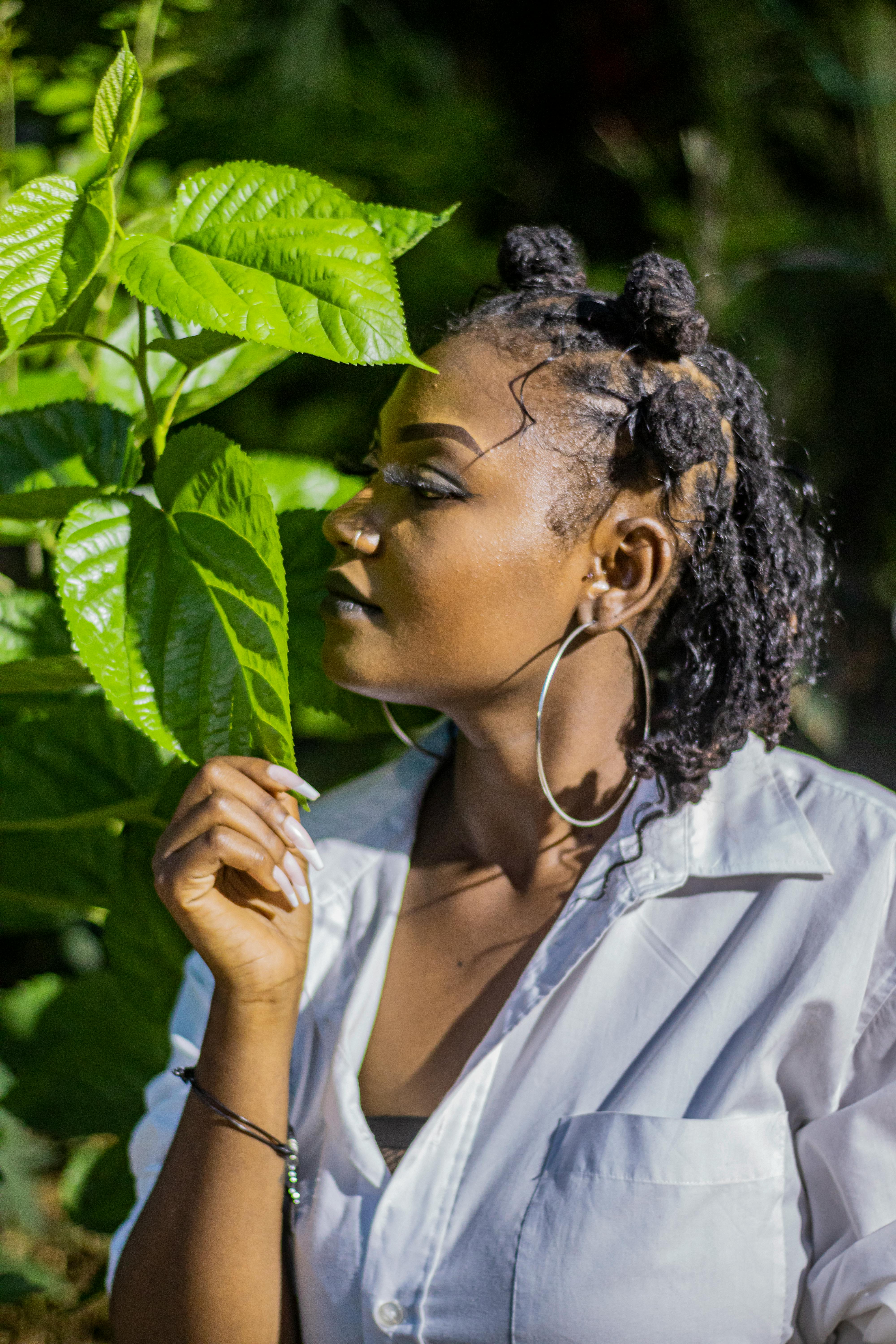Woman Admiring Green Leaves in Nairobi Sunlight · Free Stock Photo