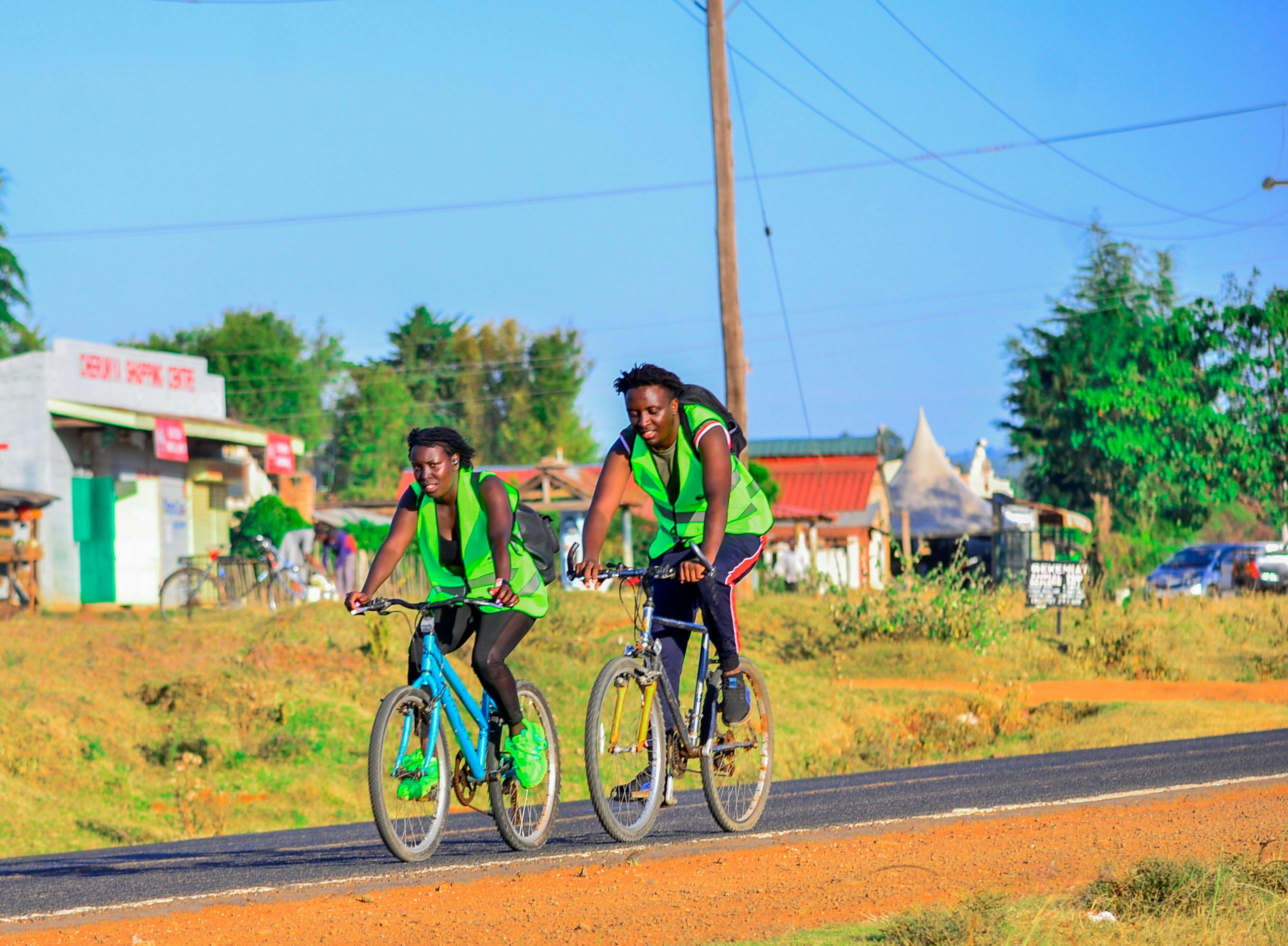 Two Cyclists Riding on Rural Road in Kenya · Free Stock Photo