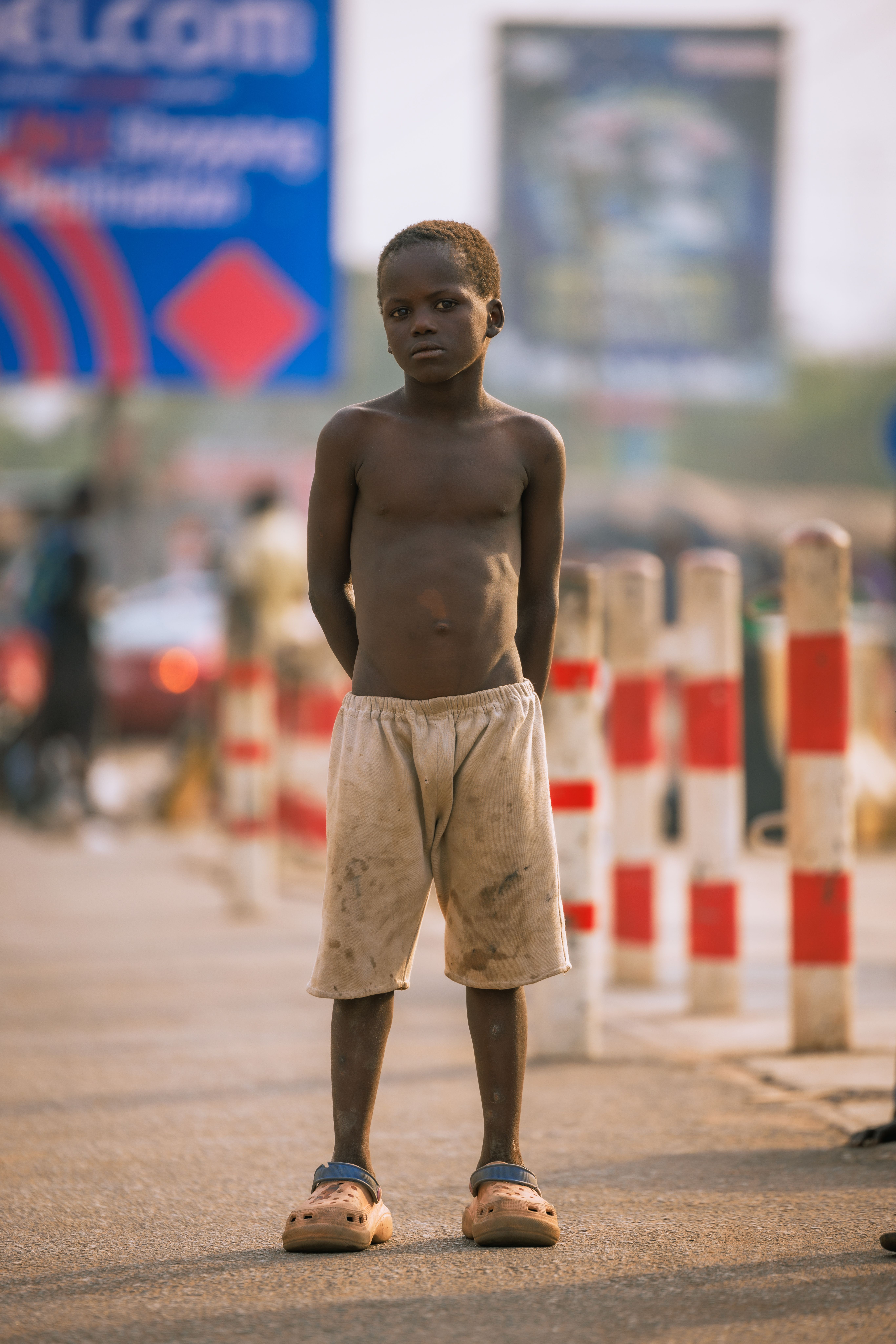 Young Boy Standing on Urban Street · Free Stock Photo