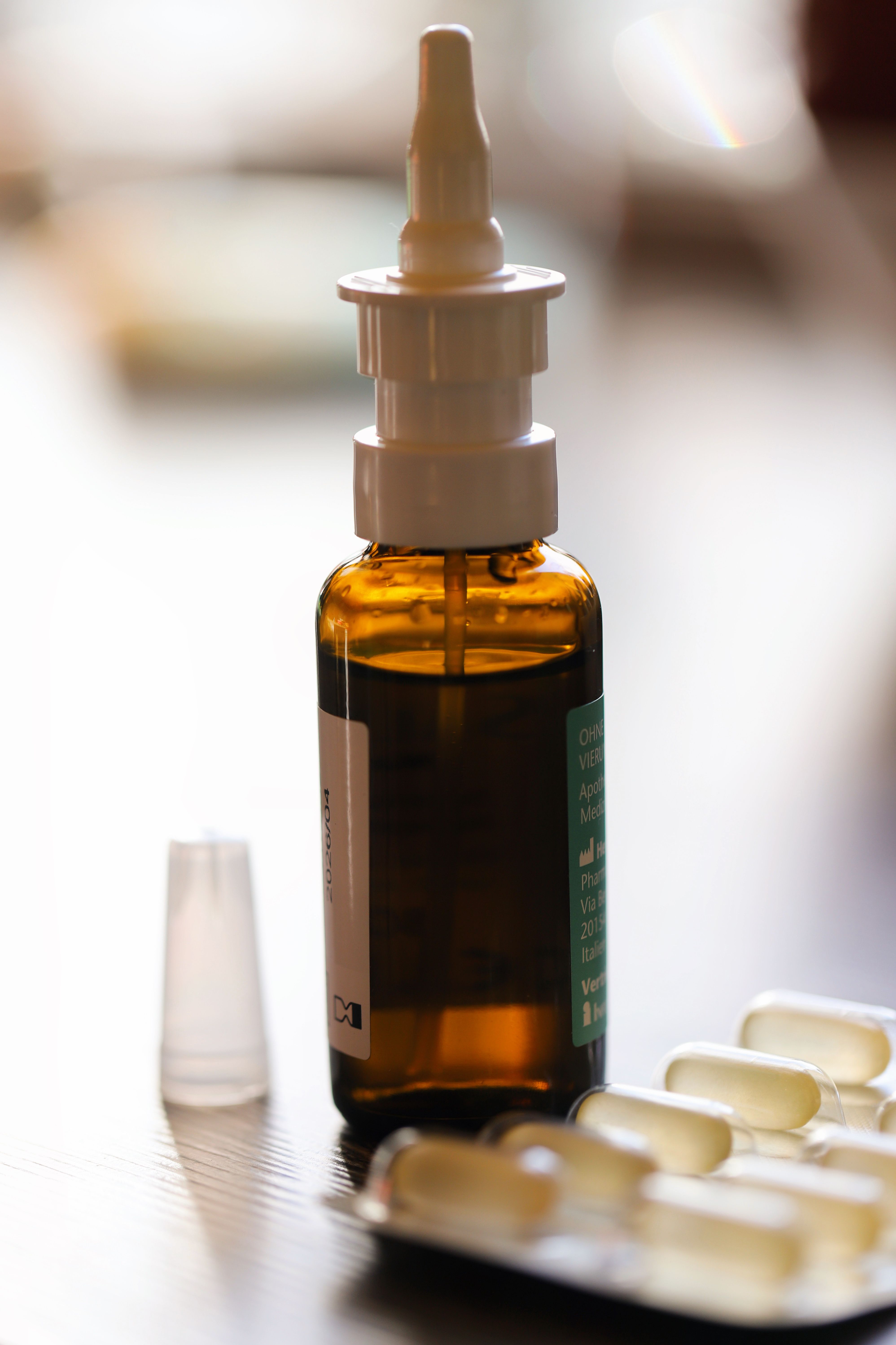 Nasal Spray Bottle with Capsules on Table · Free Stock Photo