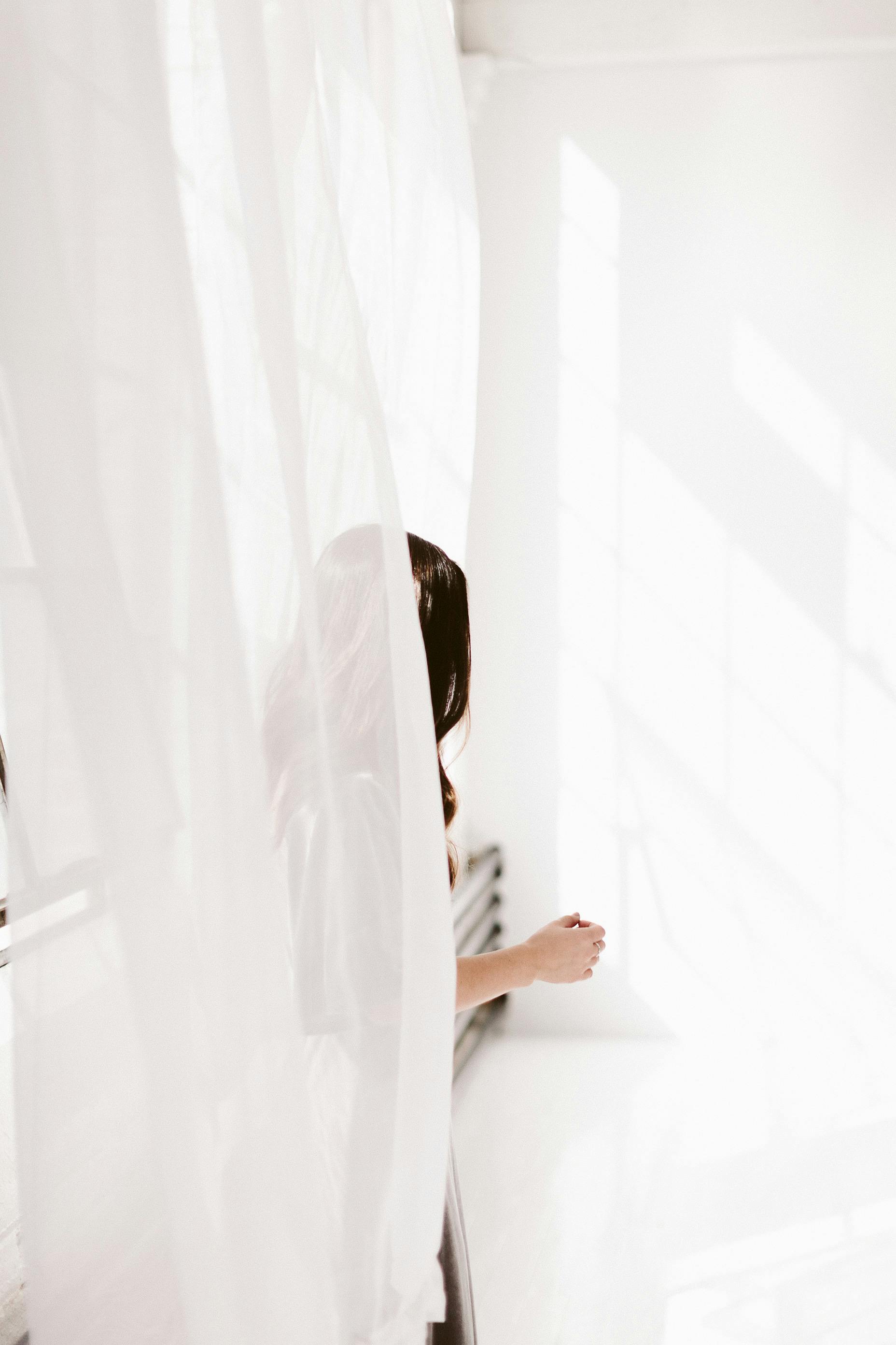 Elegant Silhouette Behind Sheer Curtains in Sunlit Room · Free Stock Photo