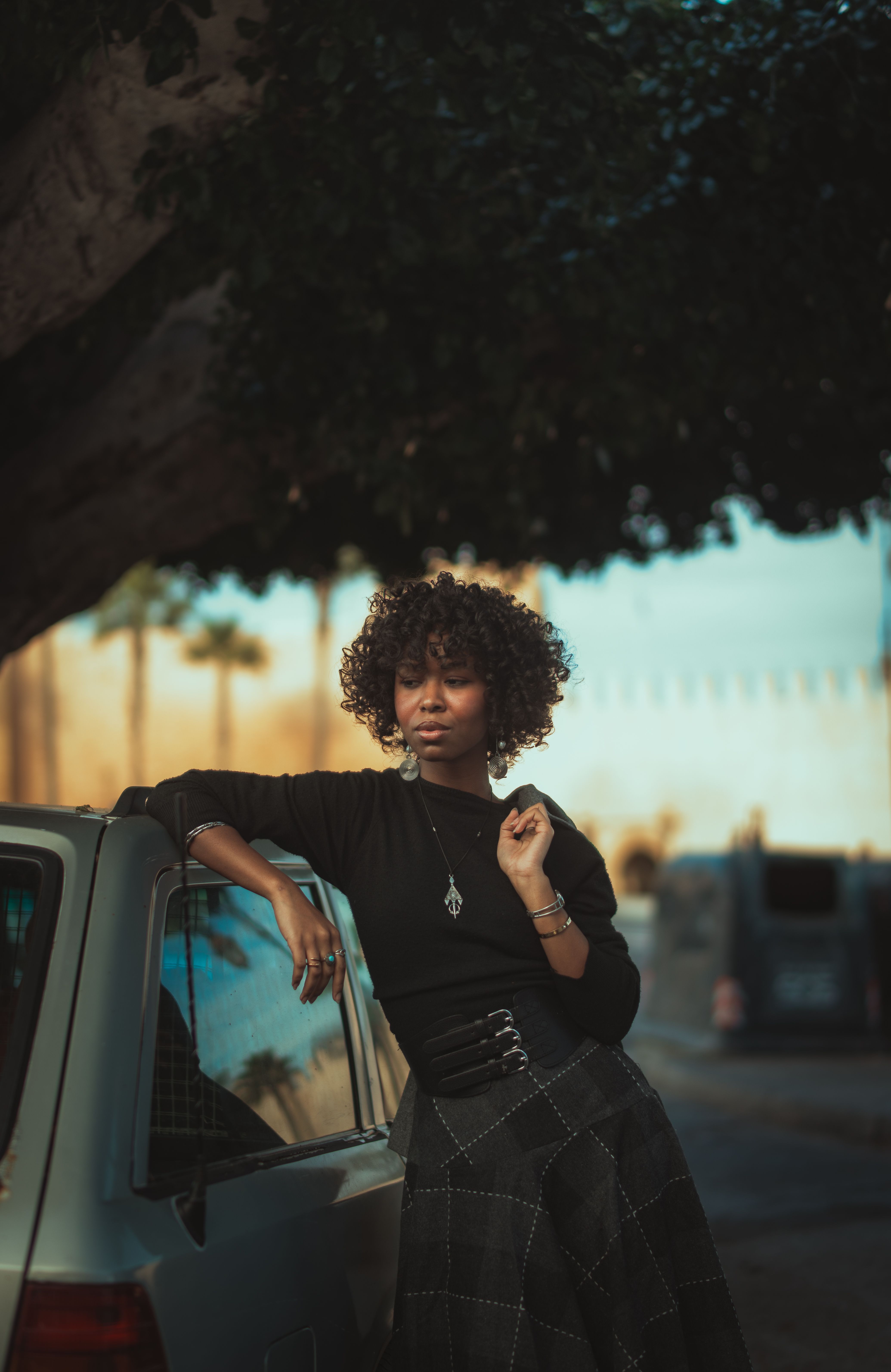 Stylish Woman Leaning Against Car Outdoors · Free Stock Photo
