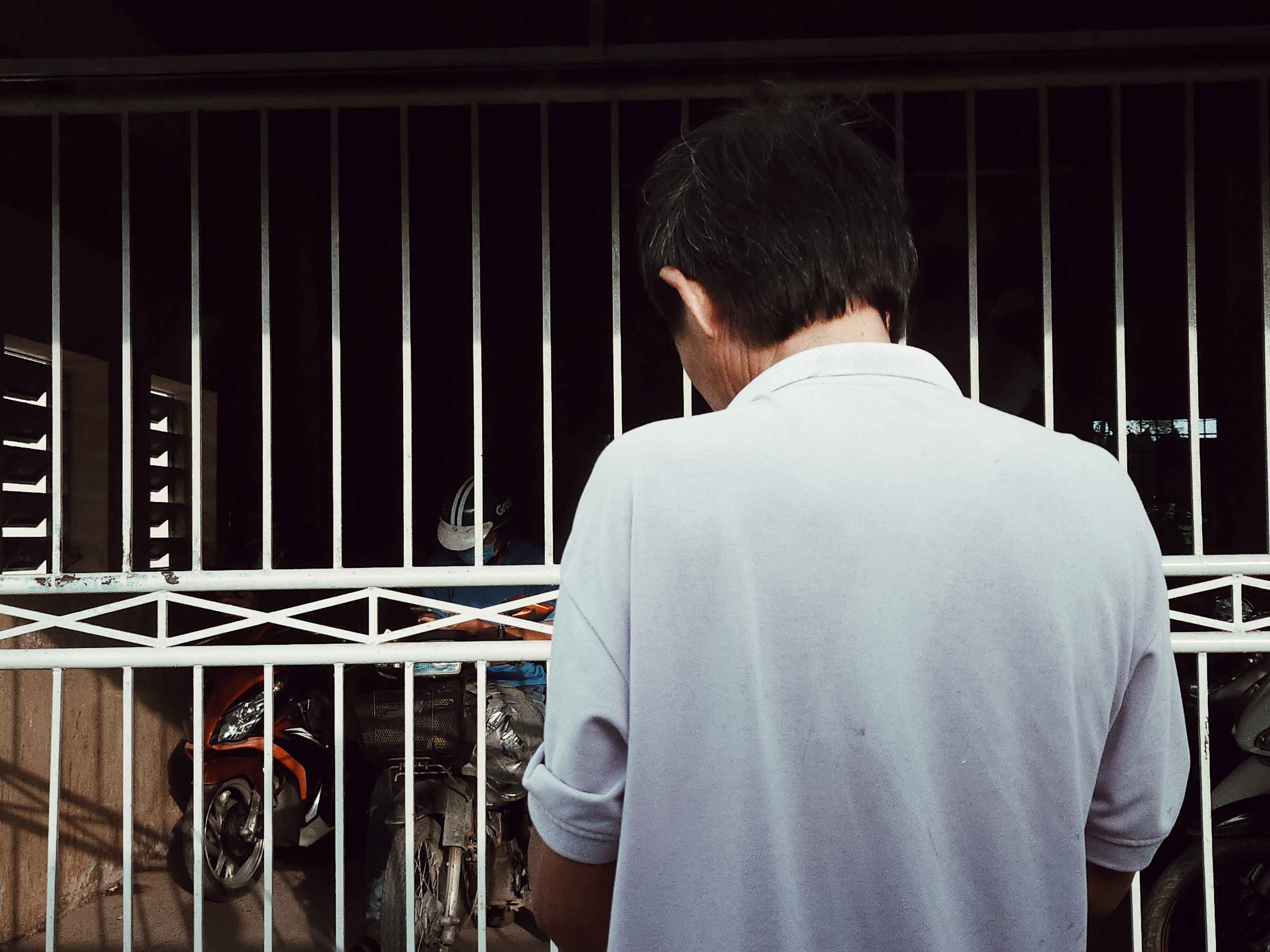 Man Standing in Front of Metal Gate · Free Stock Photo