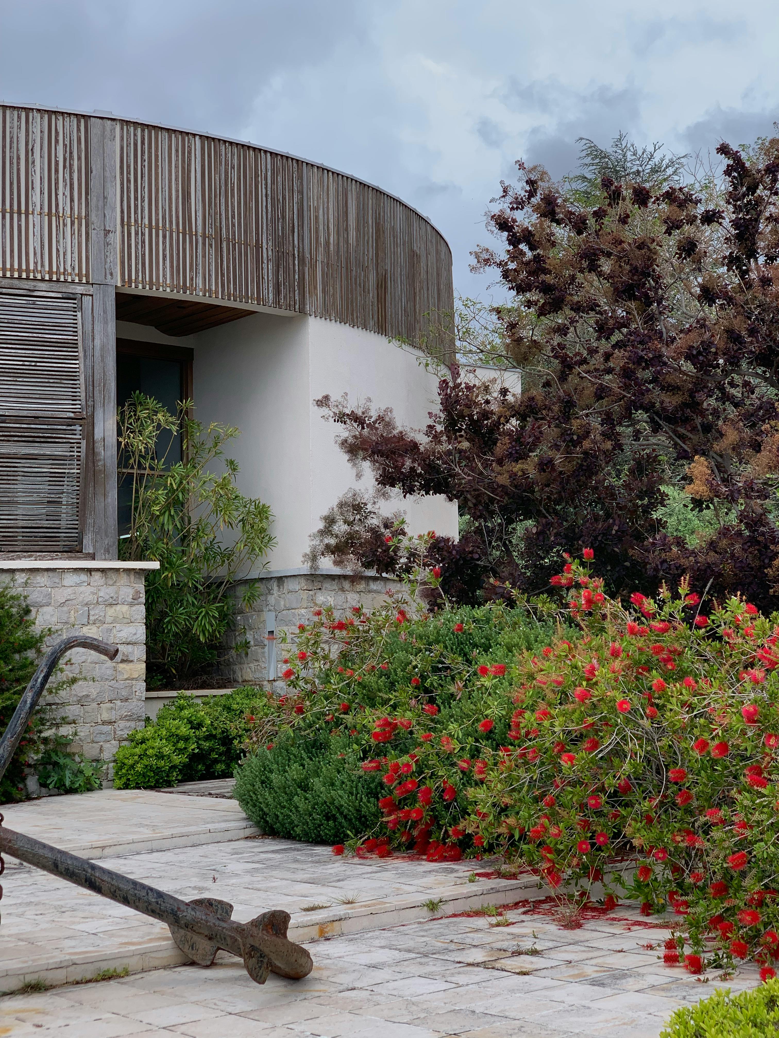 Modern Roundhouse with Lush Greenery and Flowers · Free Stock Photo