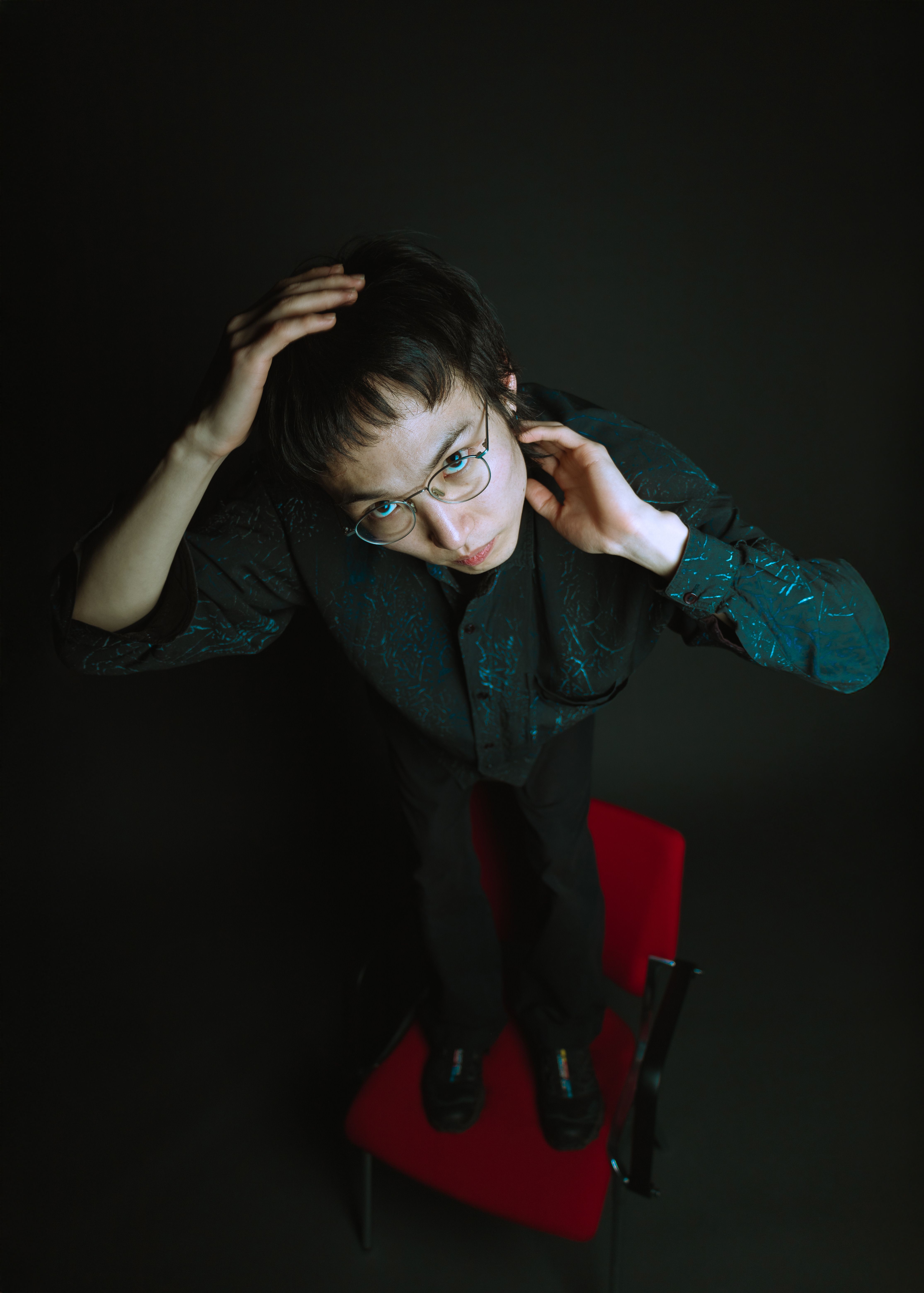 Persona Parada En Silla Roja Con Iluminación Tenue · Foto de stock gratuita