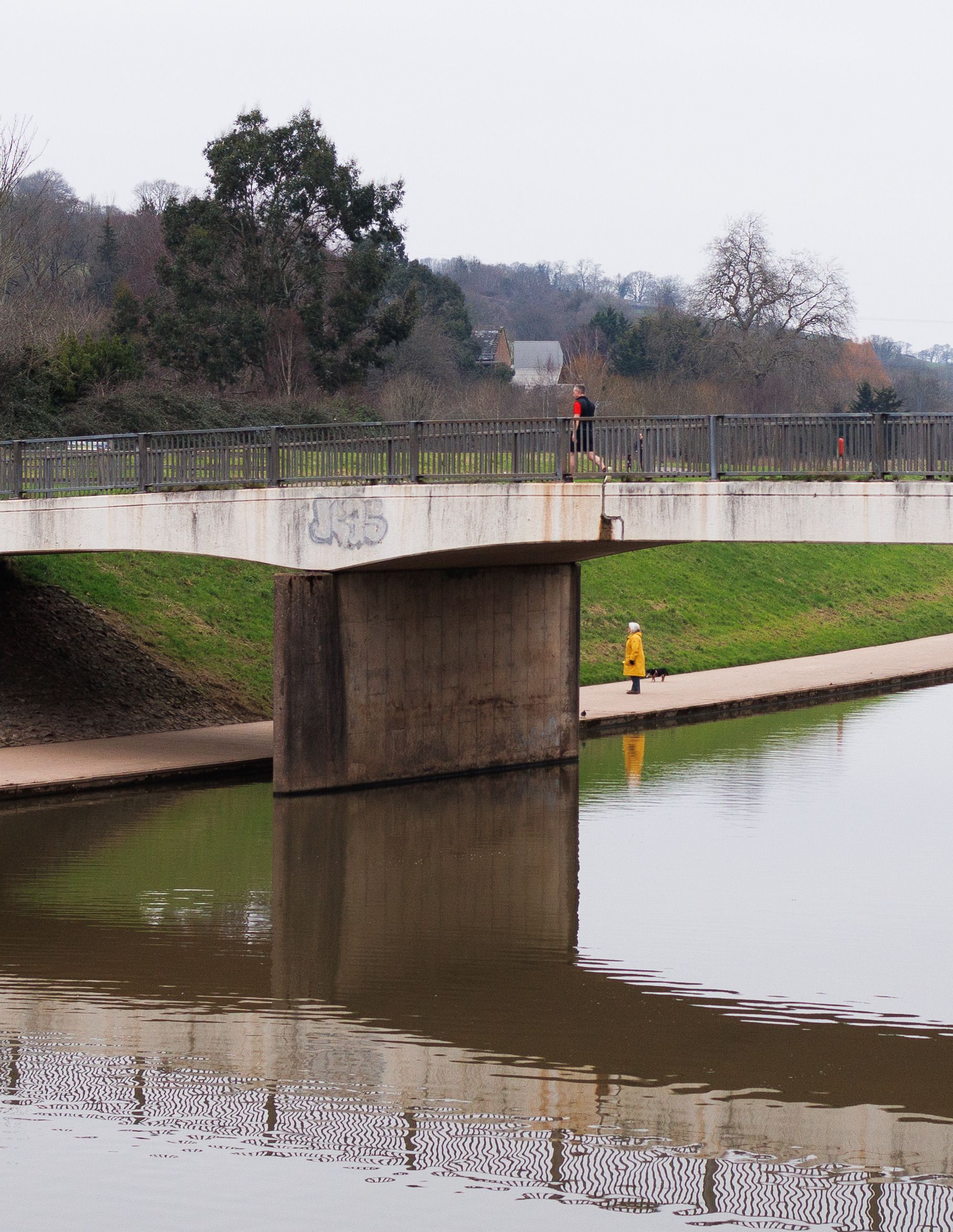 Peaceful Riverside Walk Under a Bridge · Free Stock Photo