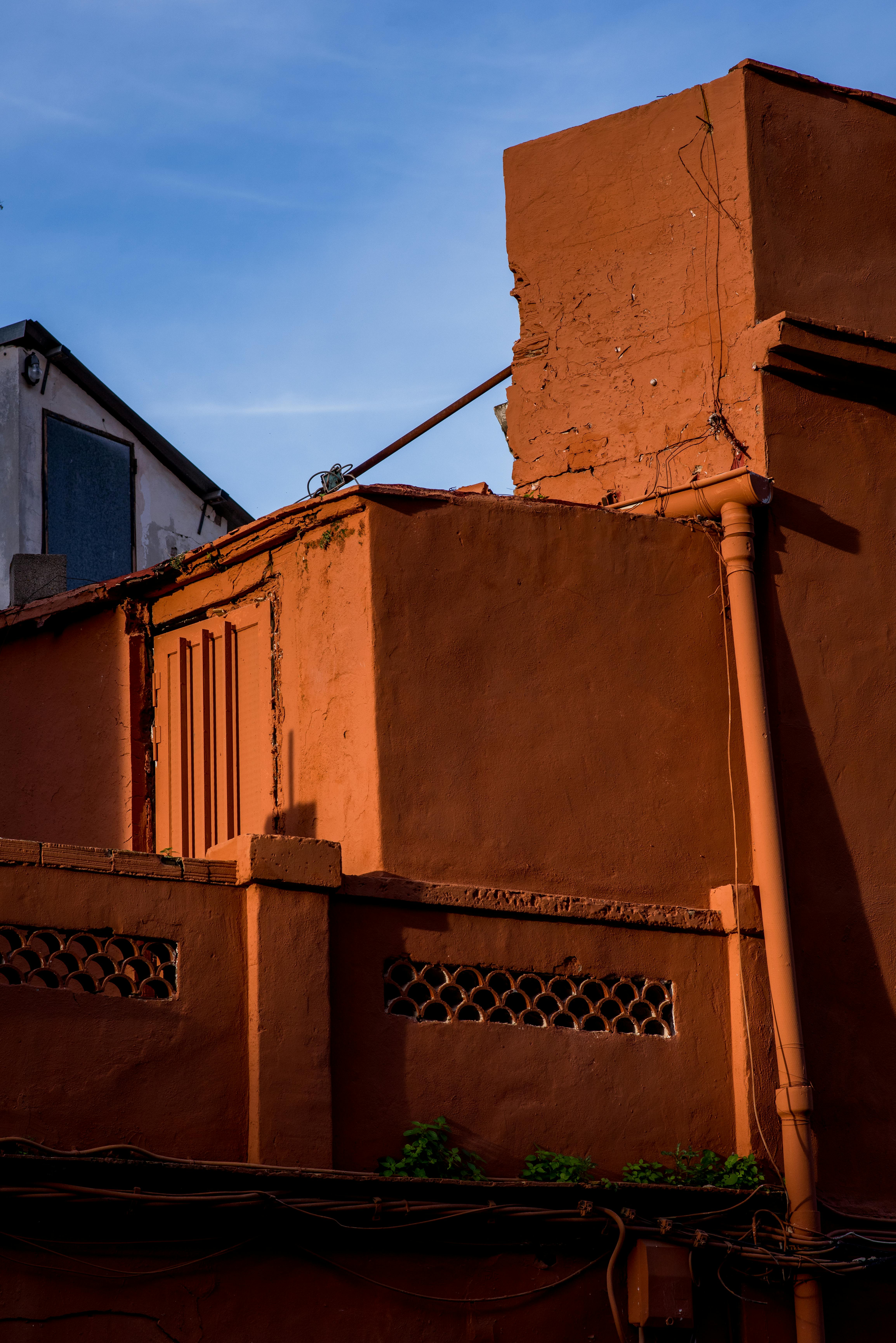 Sunlit Terracotta Building Against Blue Sky · Free Stock Photo