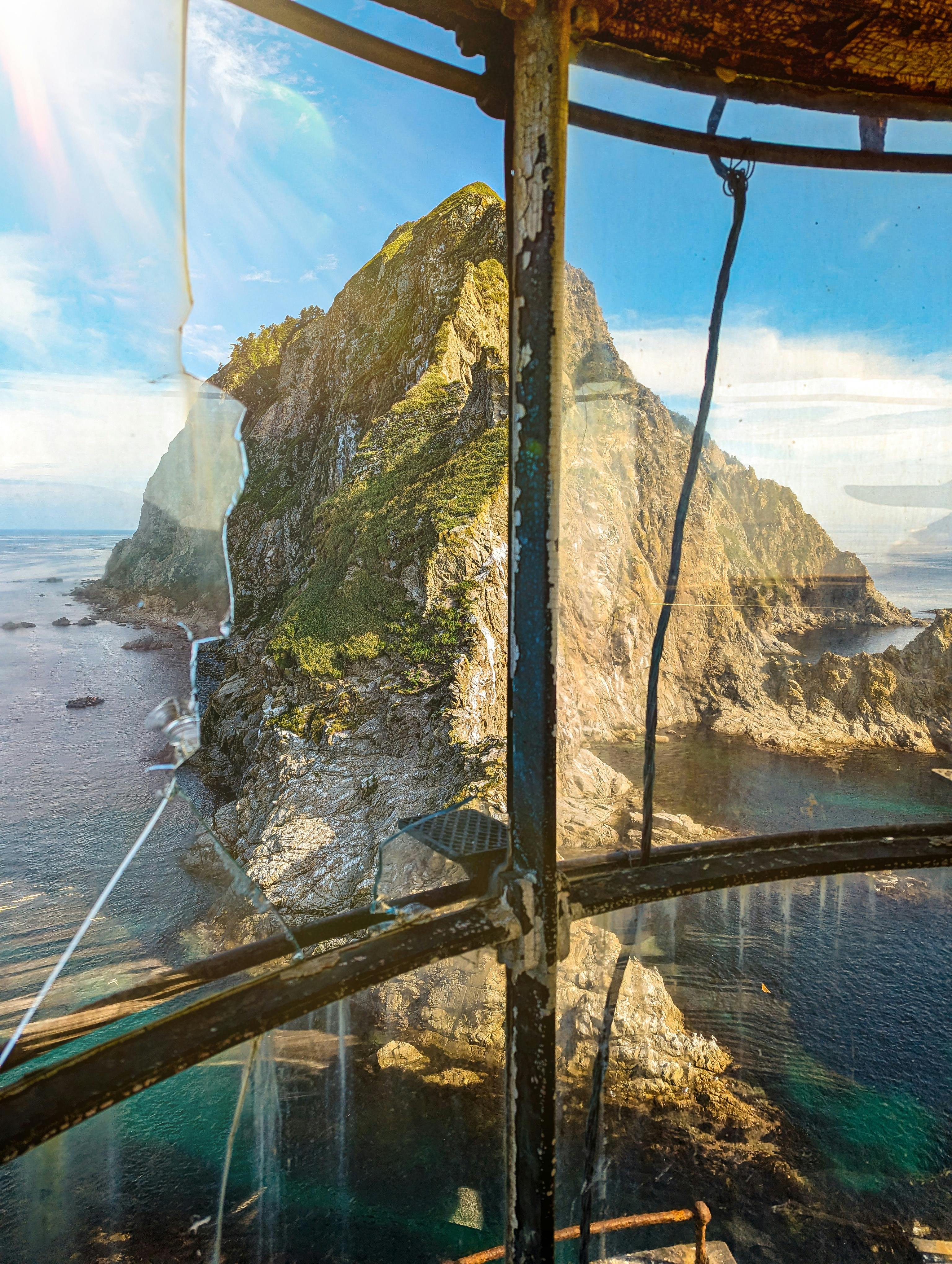 Dramatic Coastal View Through Lighthouse Window · Free Stock Photo
