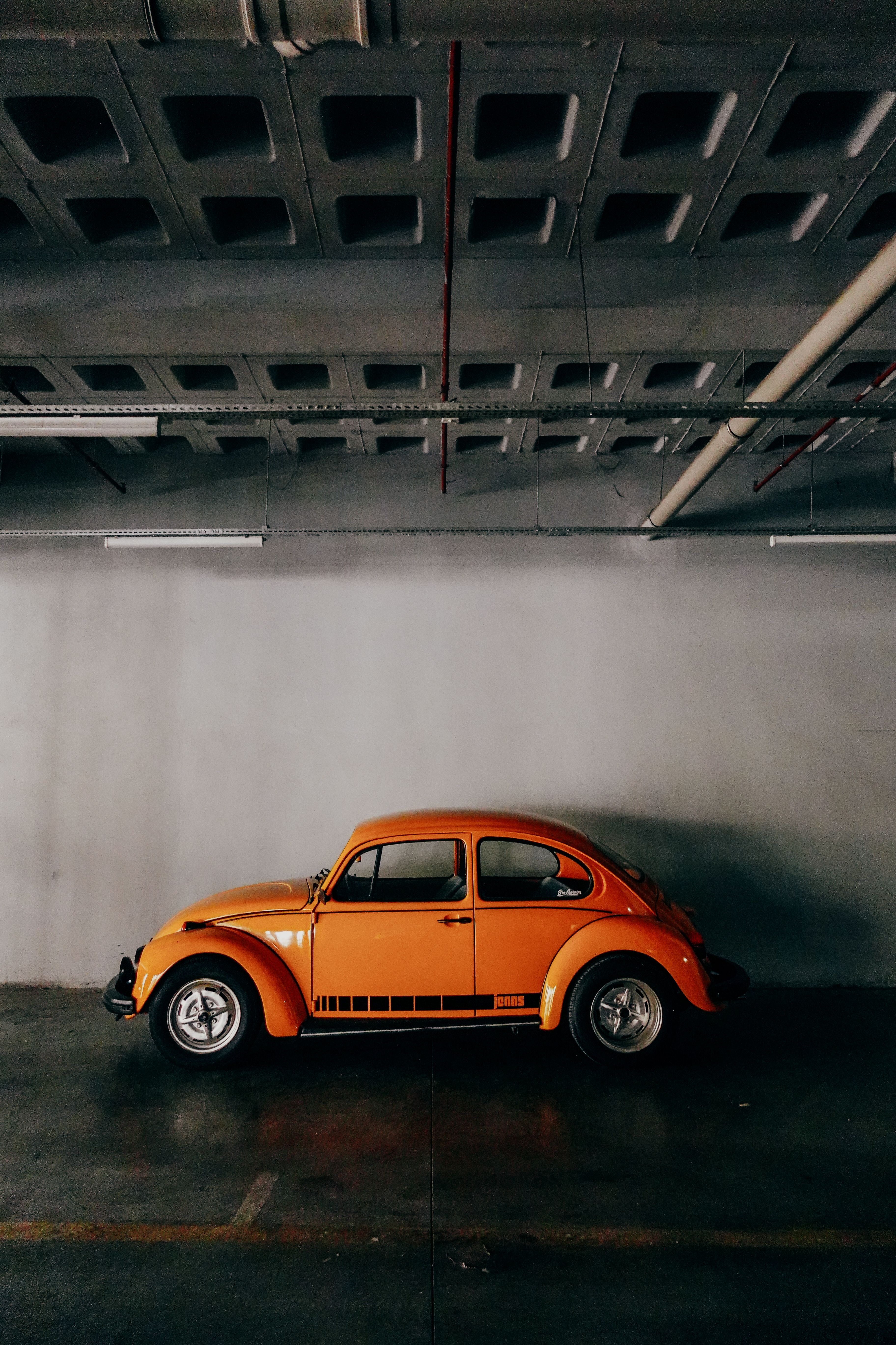 Orange Volkswagen Beetle in Urban Garage · Free Stock Photo