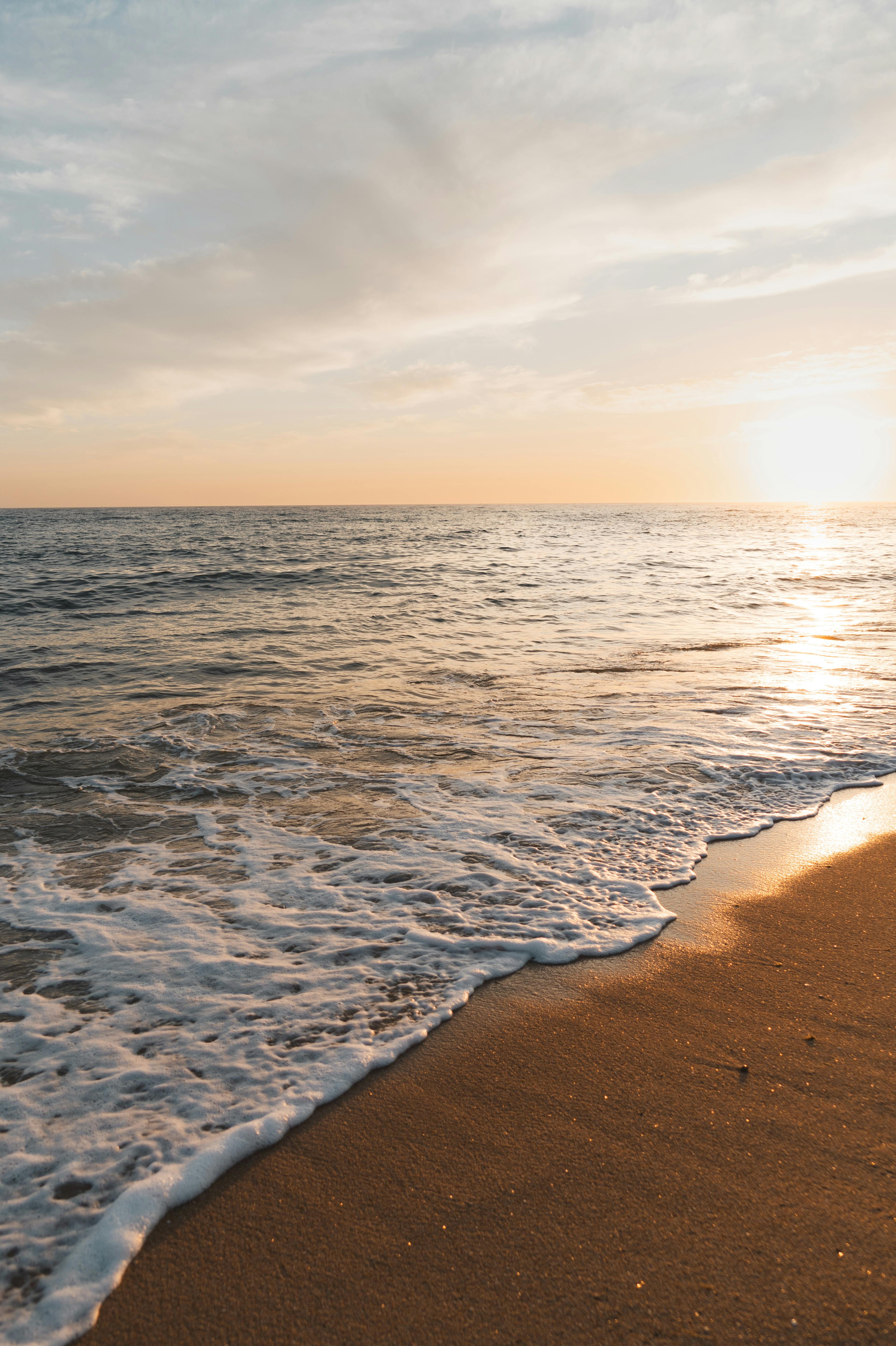 Sunset Over Ocean Waves at Serene Beach · Free Stock Photo