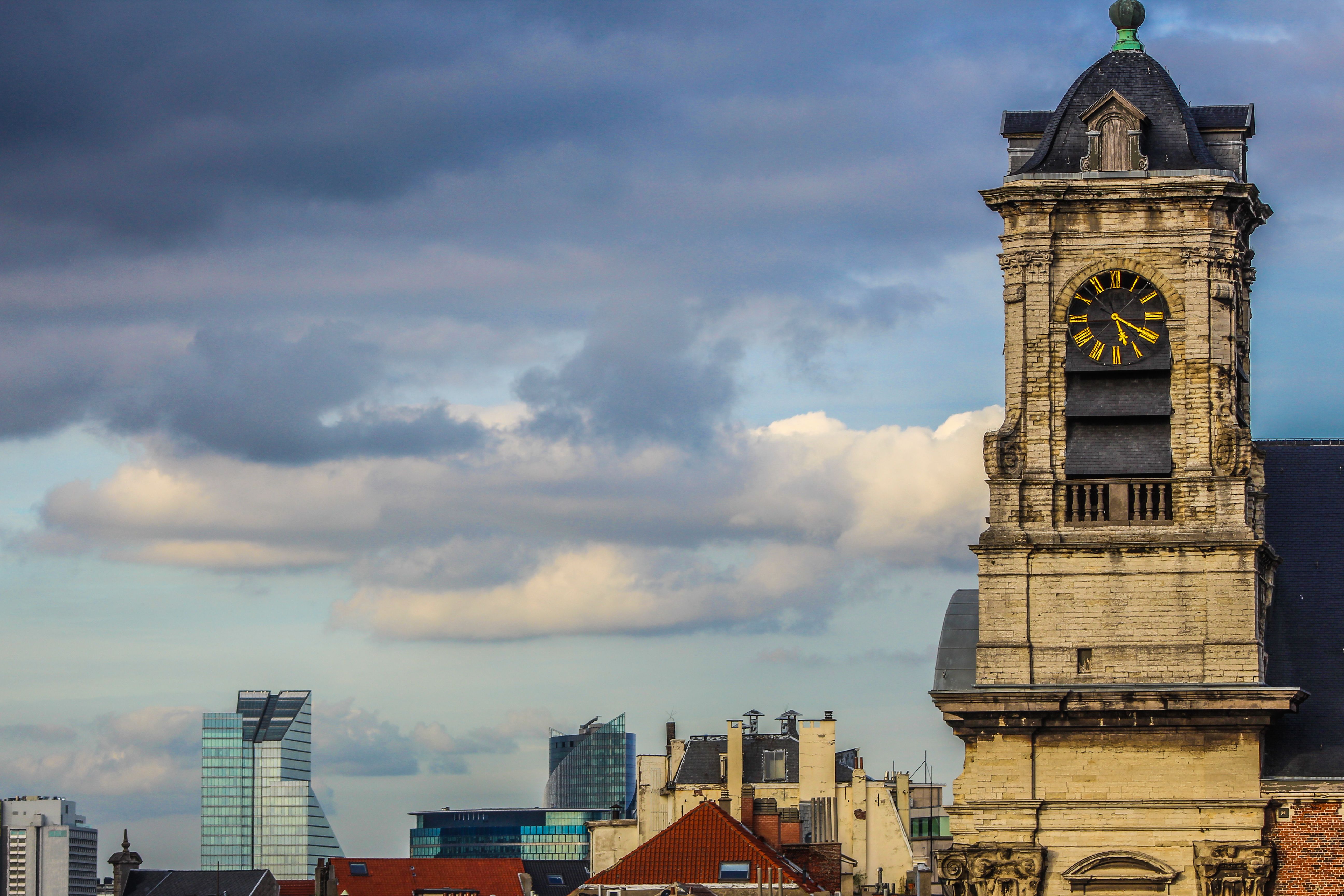 Clock Tower Overlooking Modern Cityscape at Day · Free Stock Photo