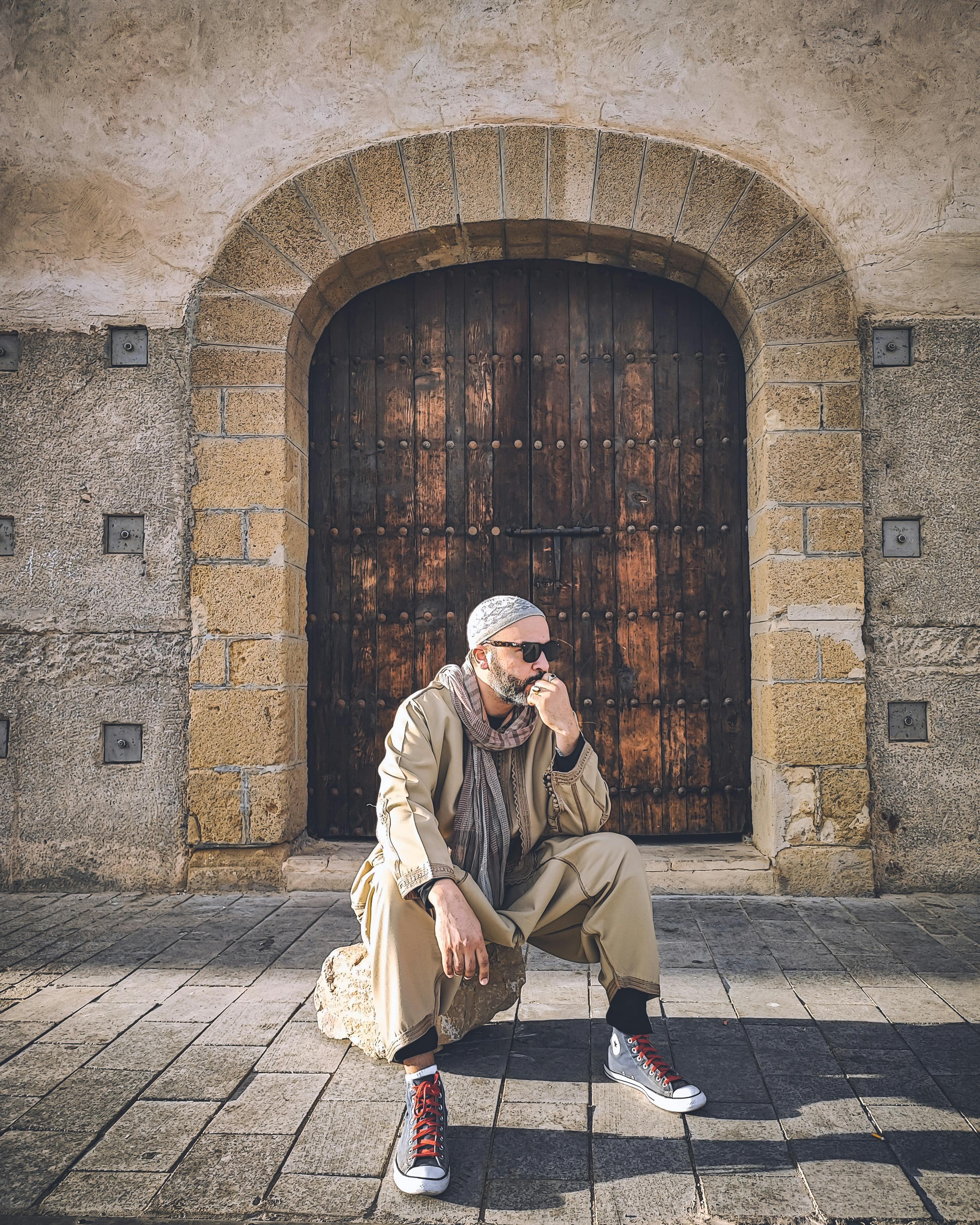 Moroccan Man in Traditional Attire by Historic Doorway · Free Stock Photo