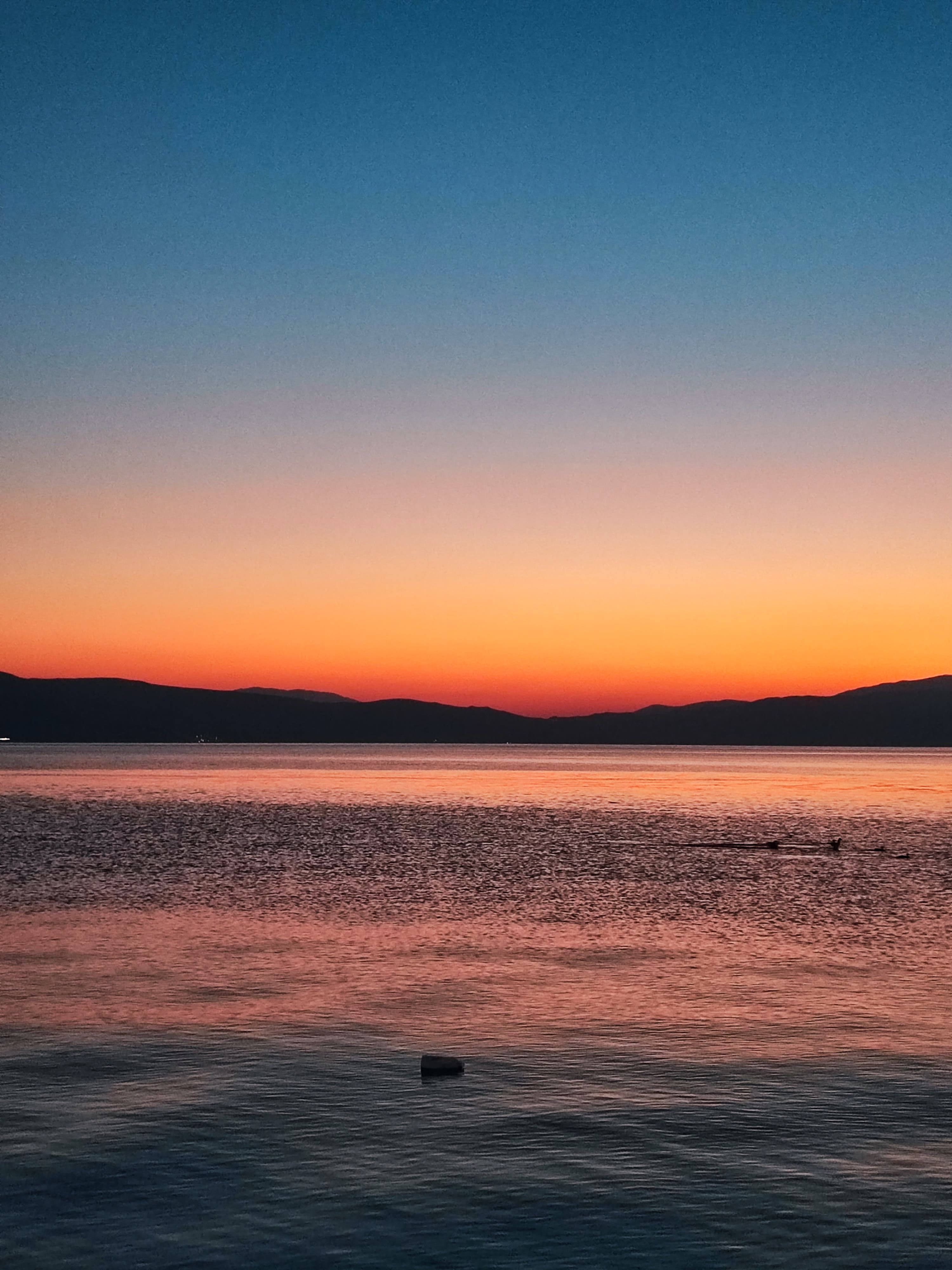 Serene Sunset Over Calm Lake Waters · Free Stock Photo