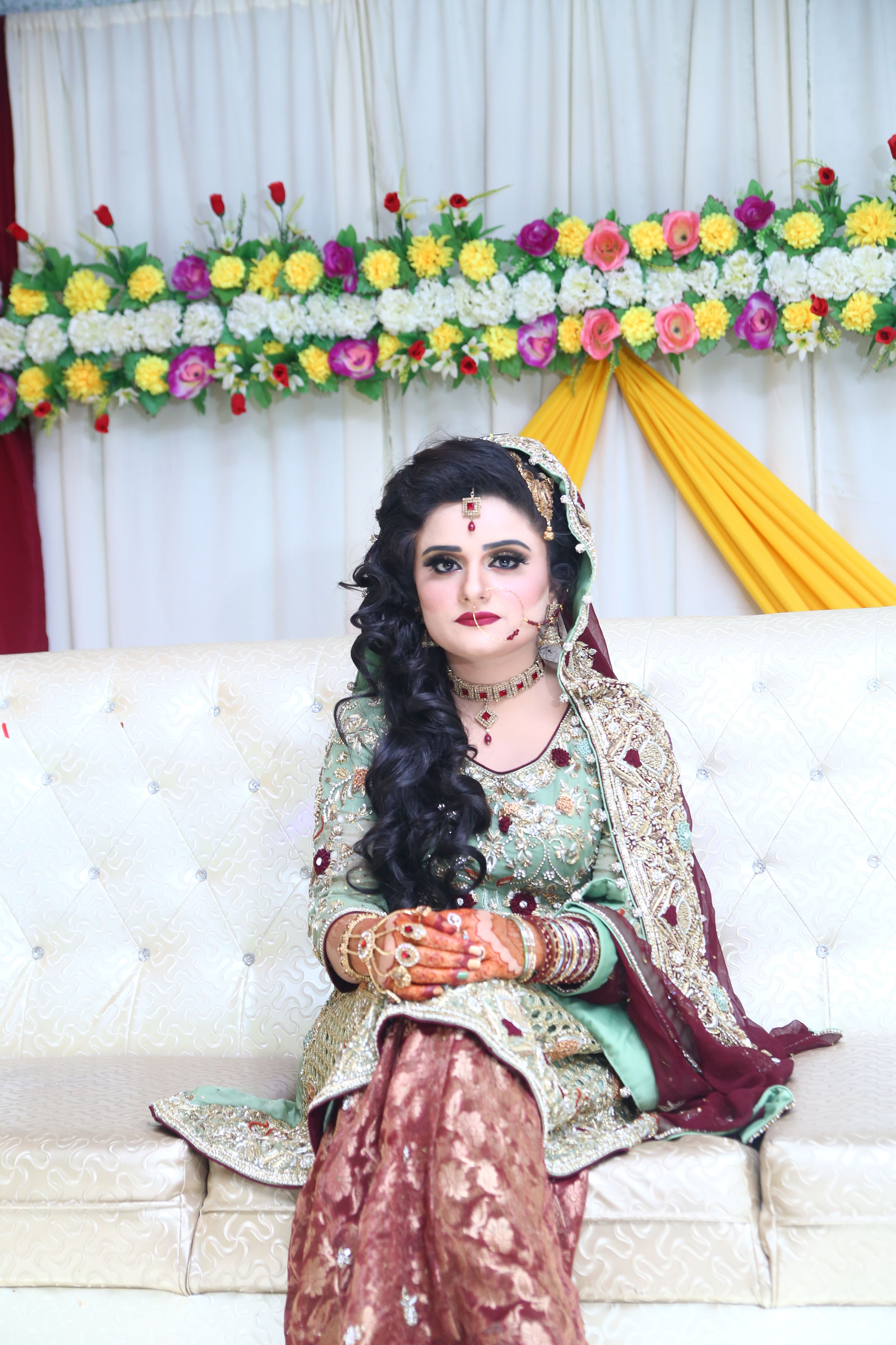 Elegant Indian Bride Seated with Floral Backdrop · Free Stock Photo