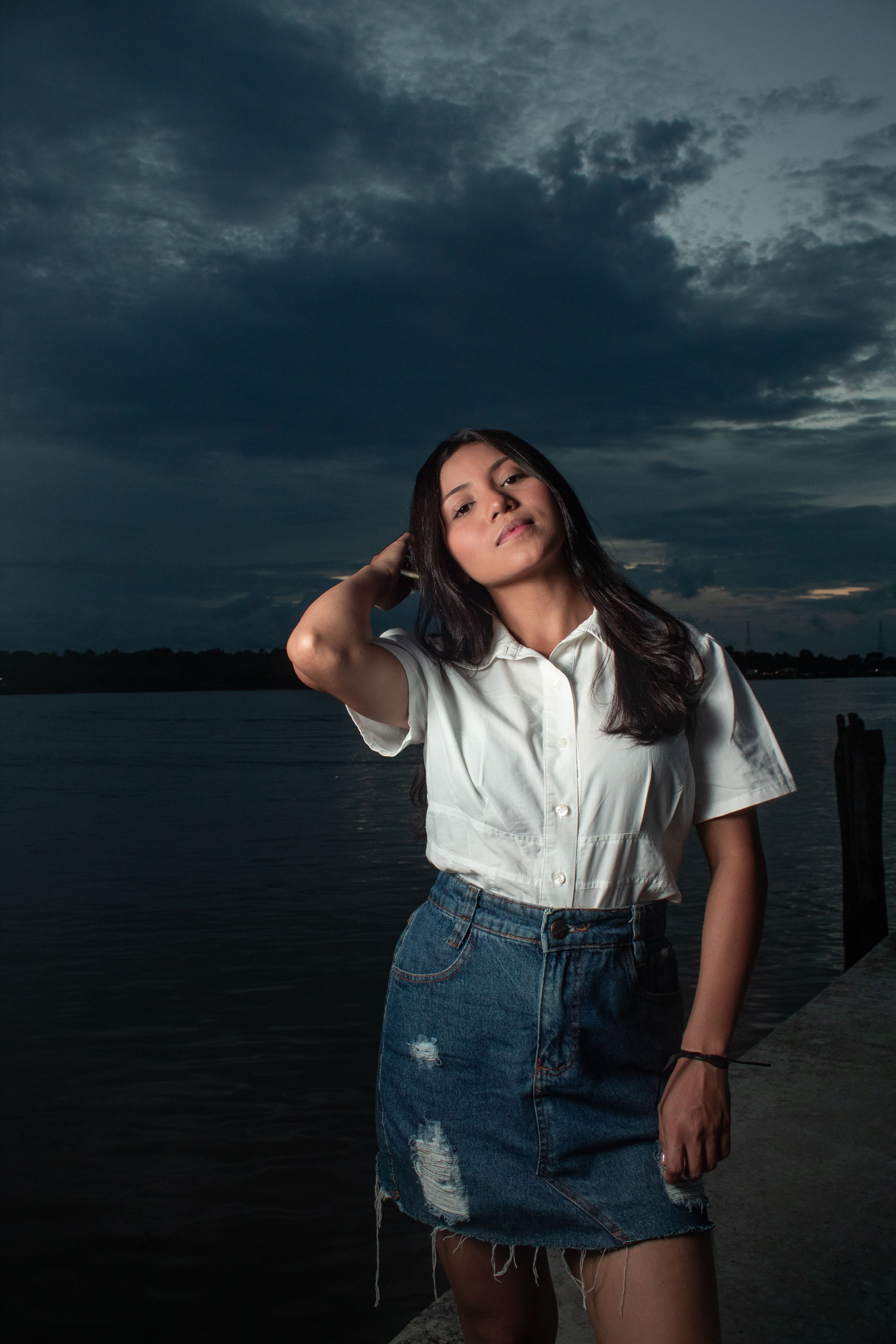 Serene Portrait by River under Dramatic Sky · Free Stock Photo