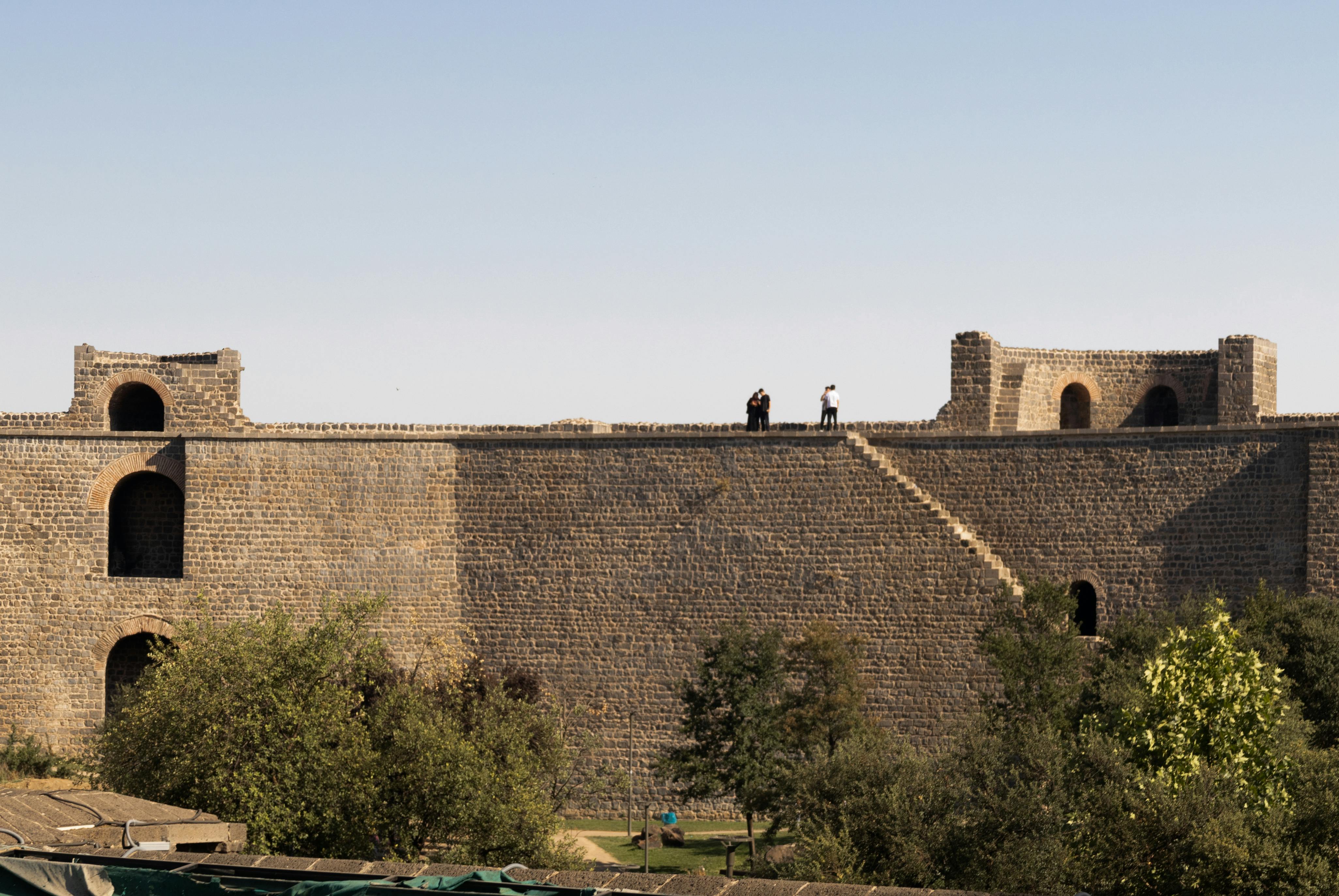 Ancient Stone Fort with People Exploring · Free Stock Photo