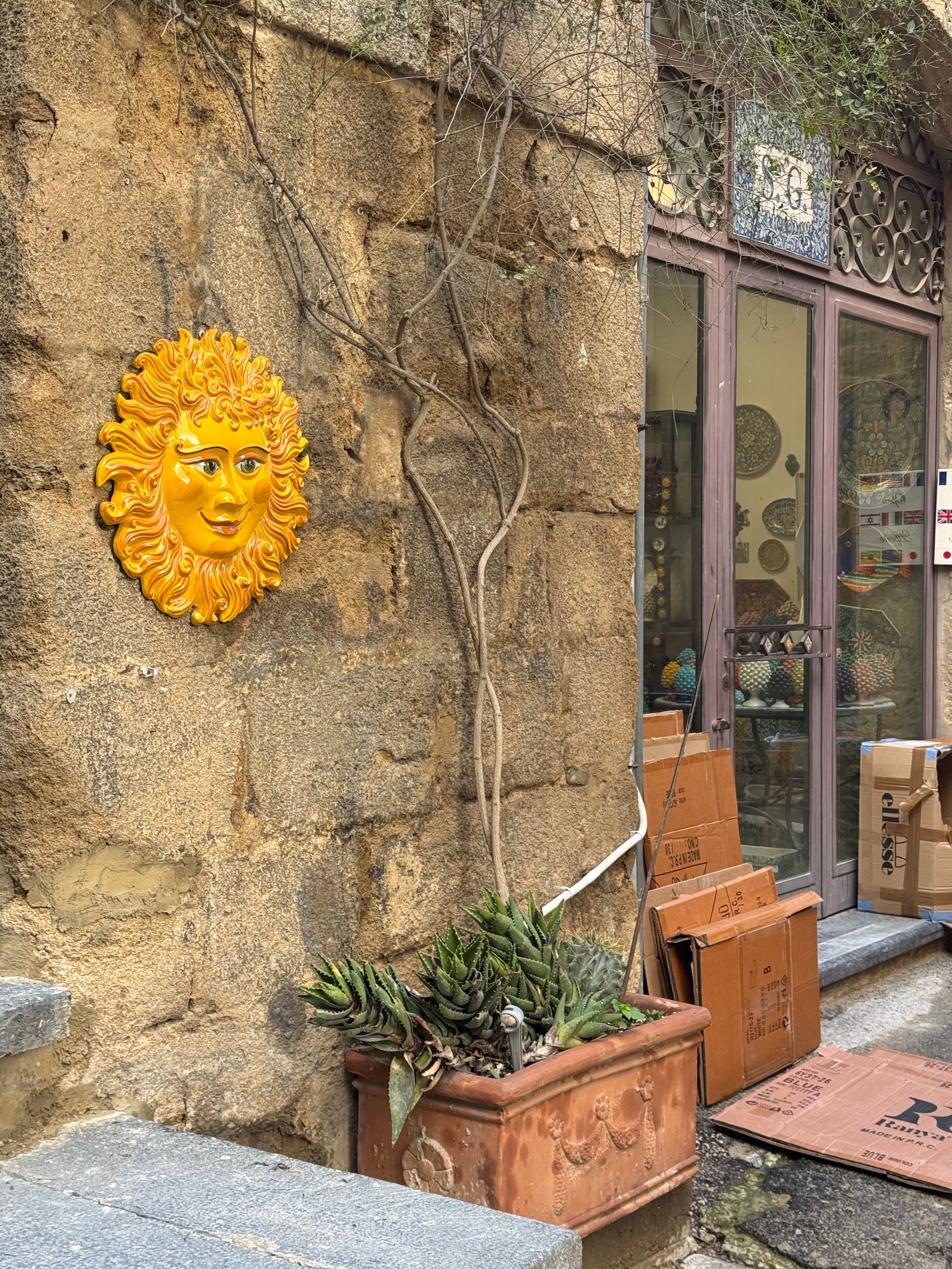 Rustic Stone Wall with Sun Face Decoration · Free Stock Photo