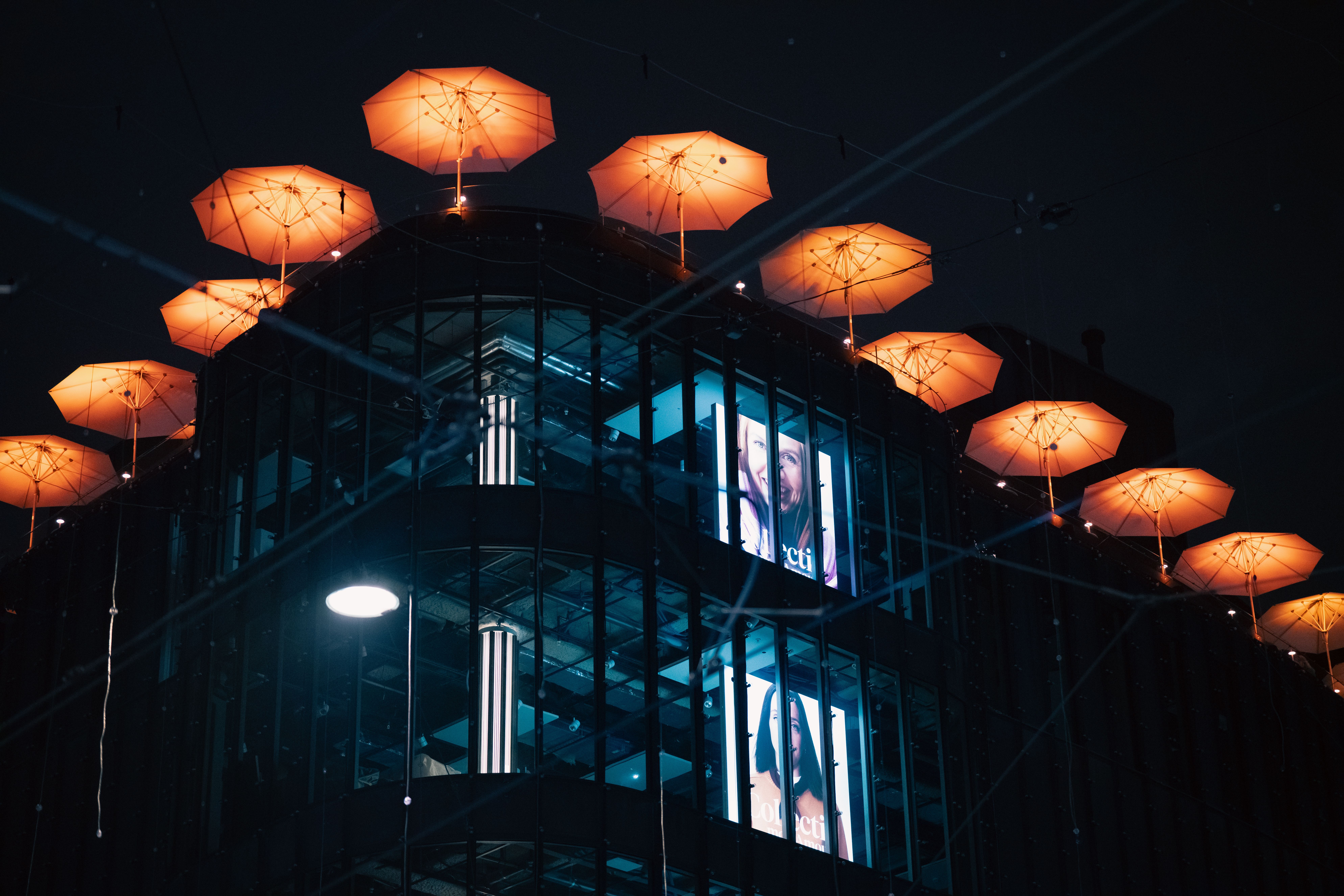 Nighttime Building with Illuminated Umbrellas · Free Stock Photo
