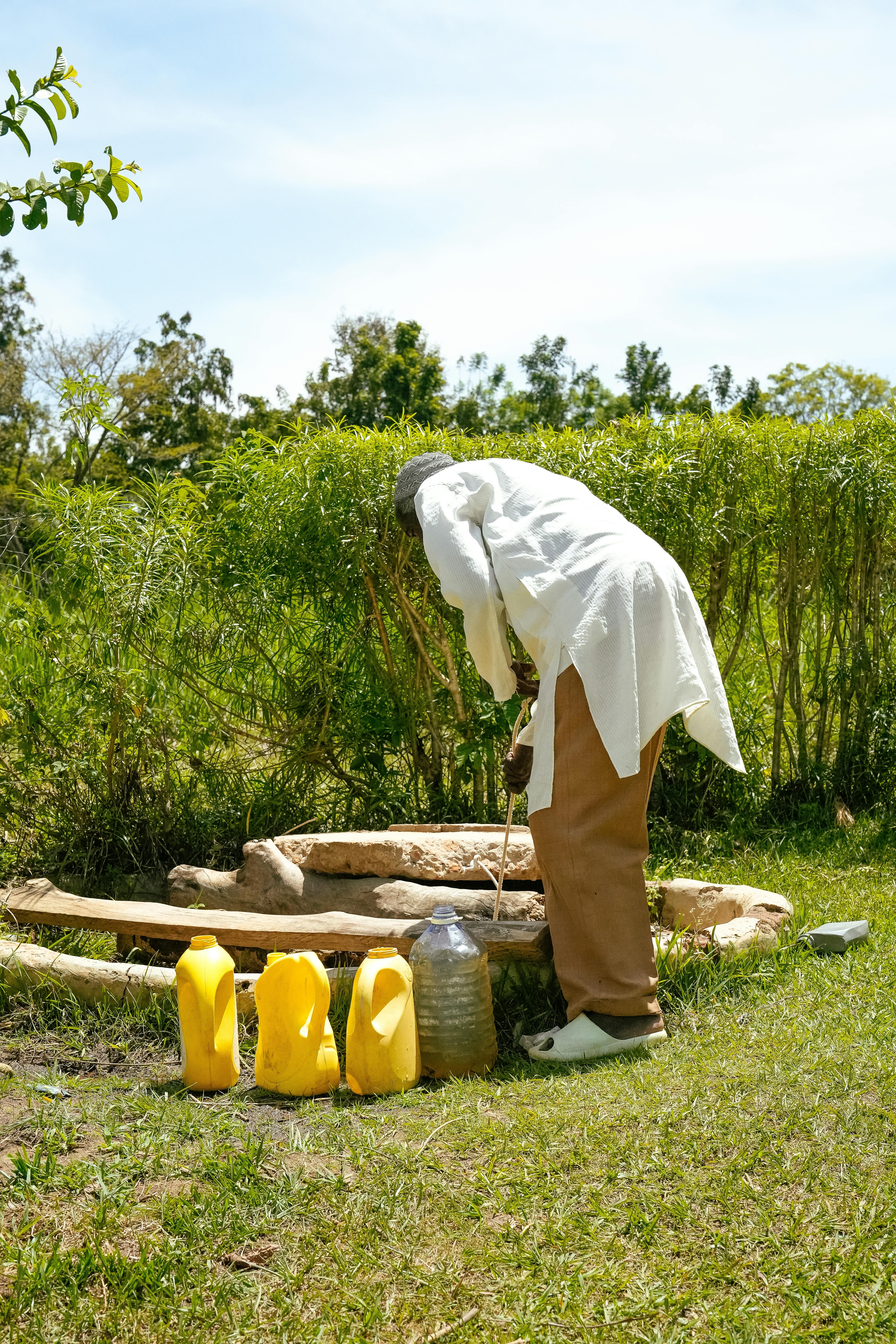 Person Fetching Water from Outdoor Well · Free Stock Photo
