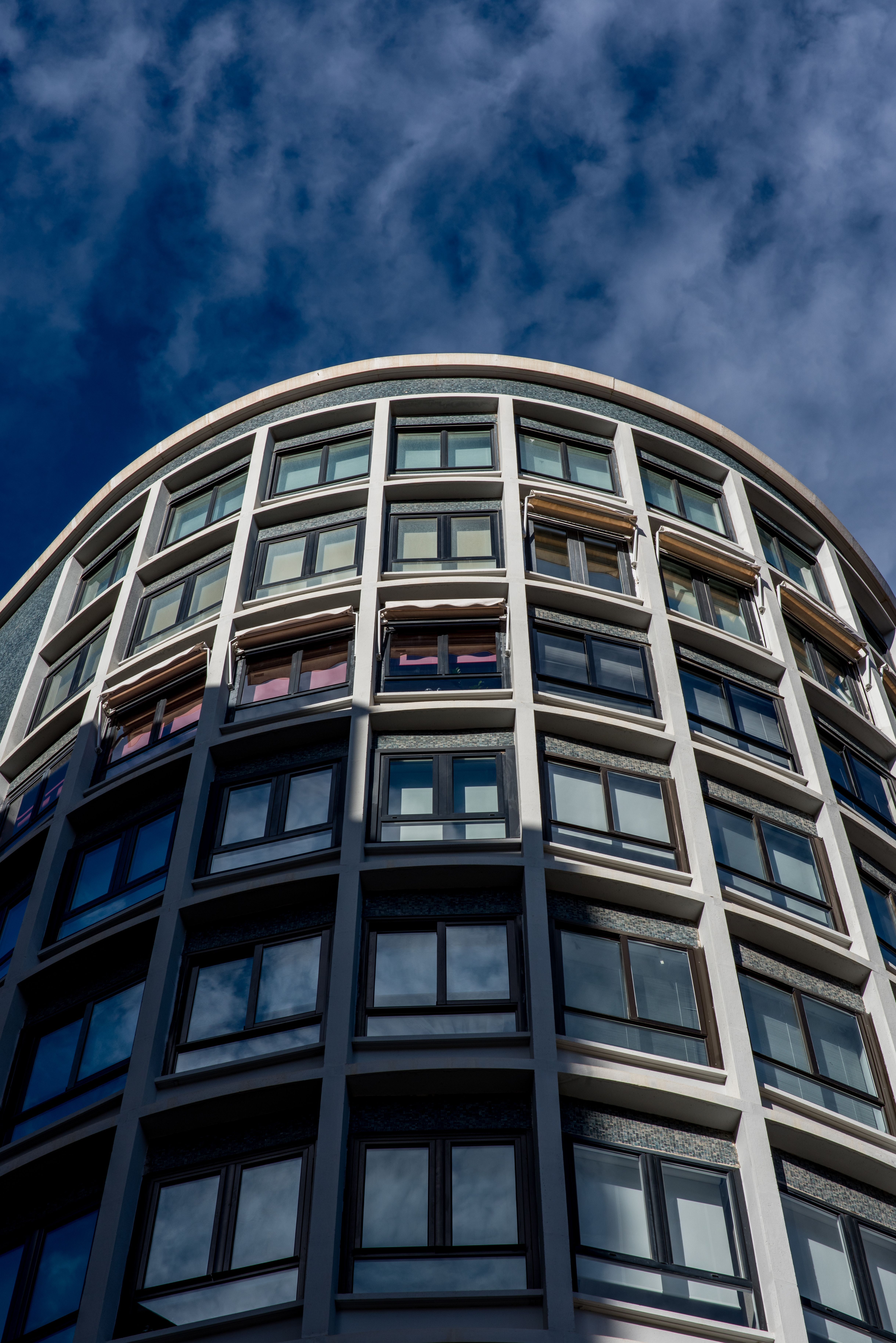 Modern Curved Building Against Blue Sky · Free Stock Photo