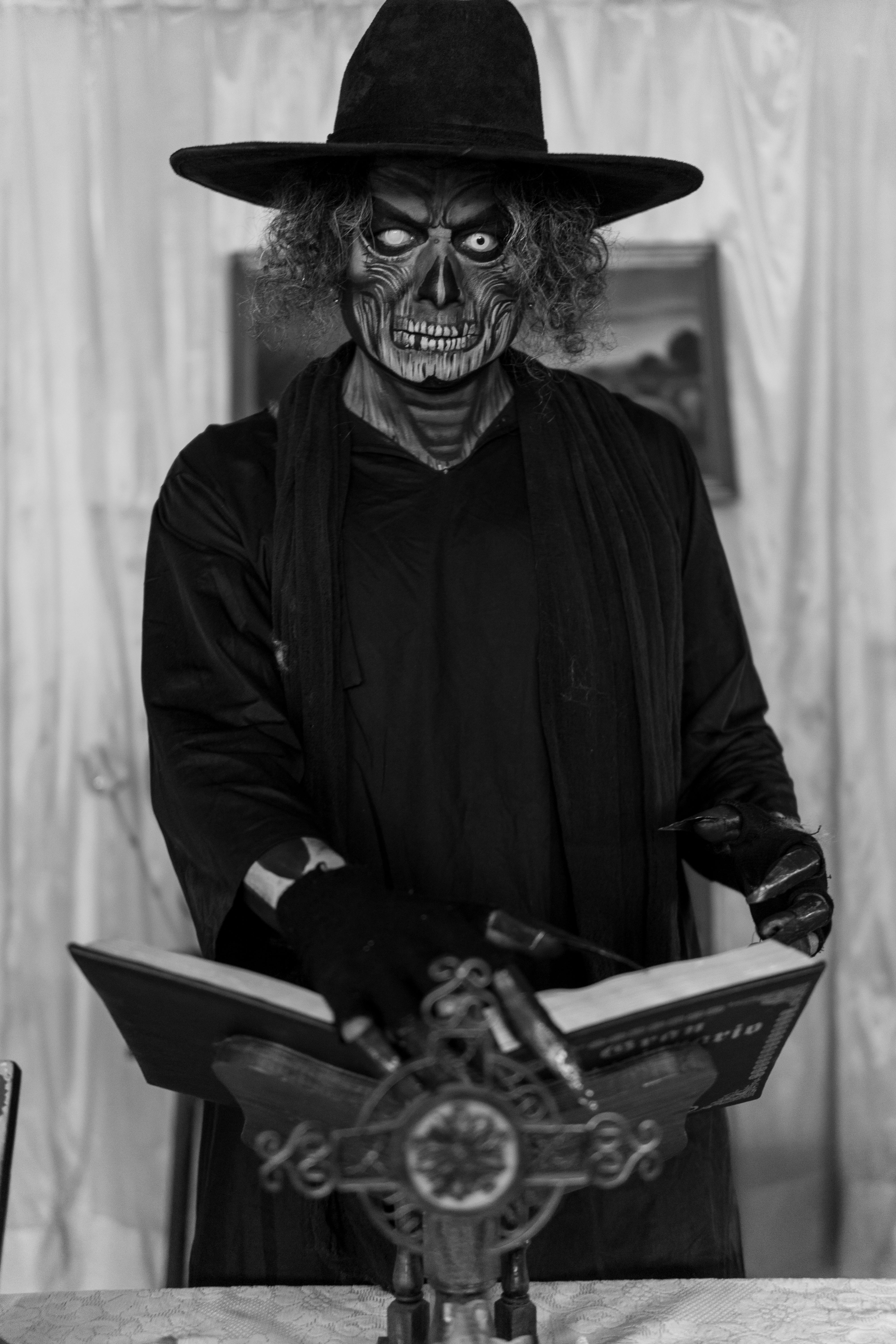 Eerie Skeleton Masked Figure at Table · Free Stock Photo