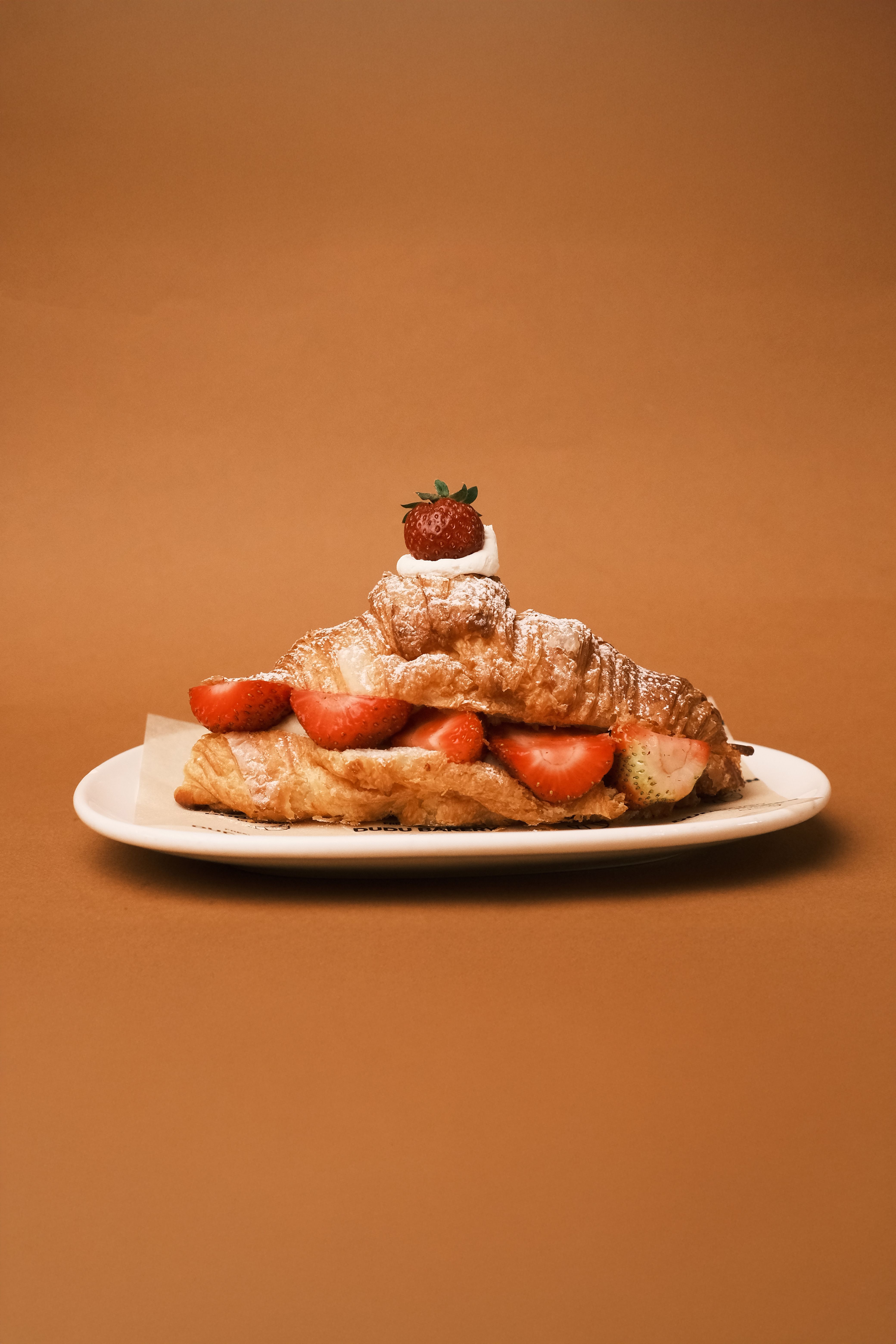 Strawberry Croissant on Plate with Mocha Backdrop · Free Stock Photo
