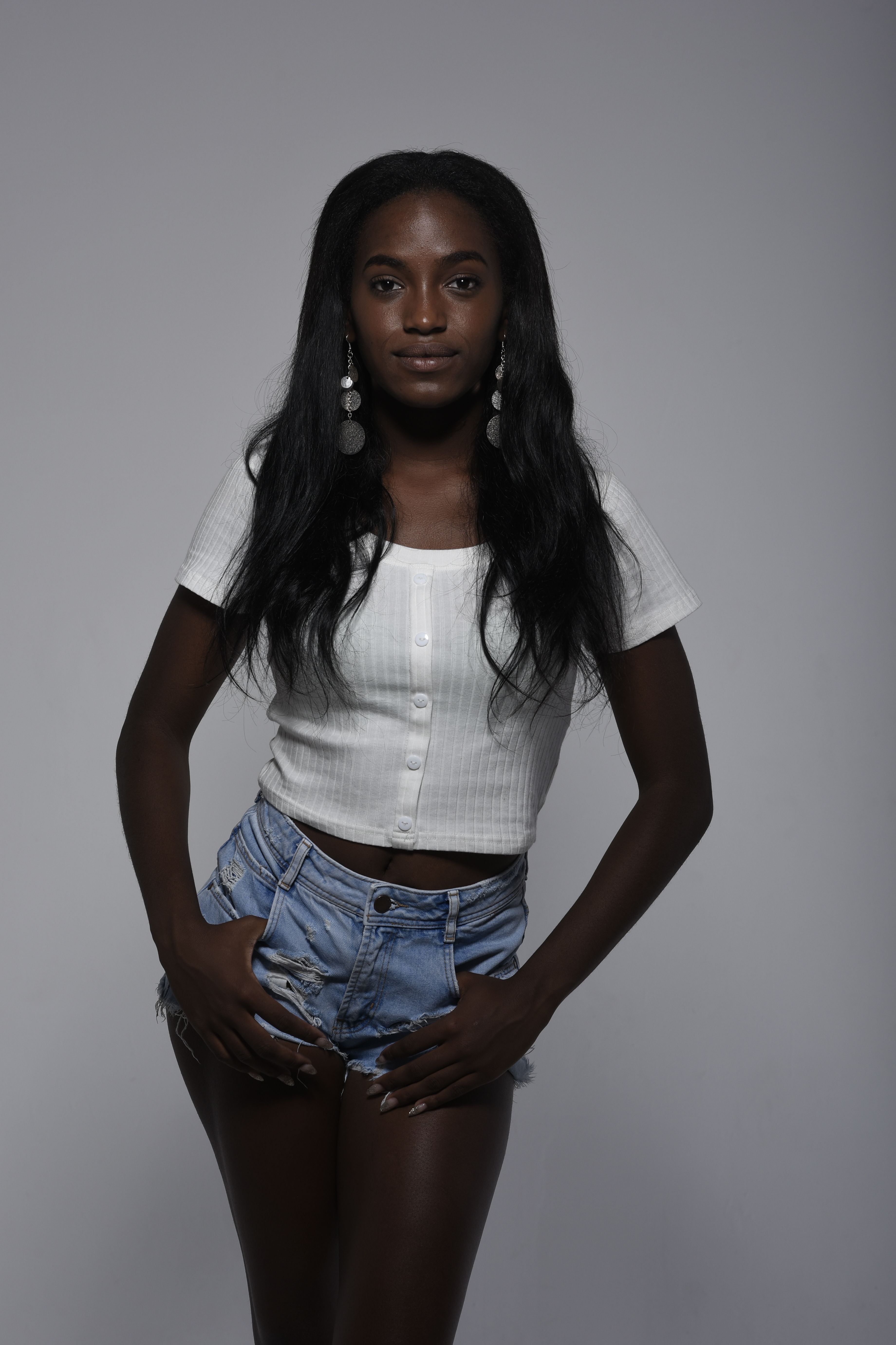 Stylish Woman in Denim Shorts on Neutral Background · Free Stock Photo