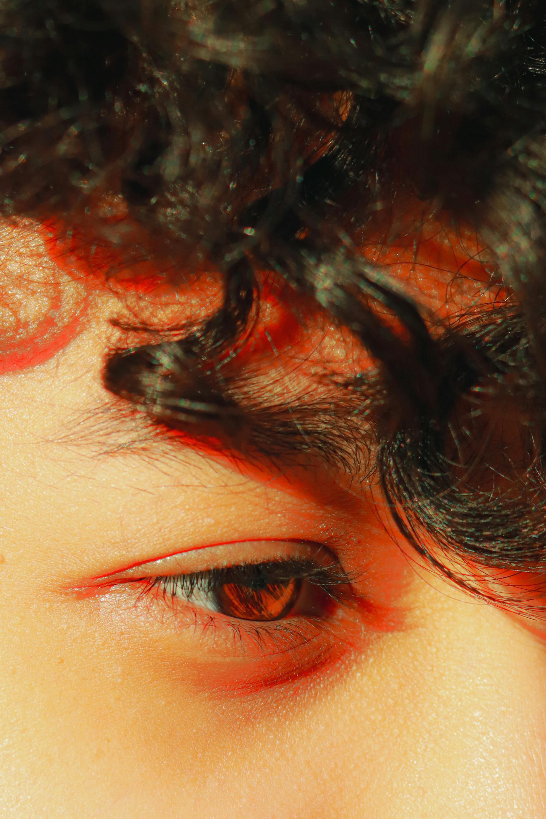 Close-up of Eye with Curly Hair in Sunlight · Free Stock Photo