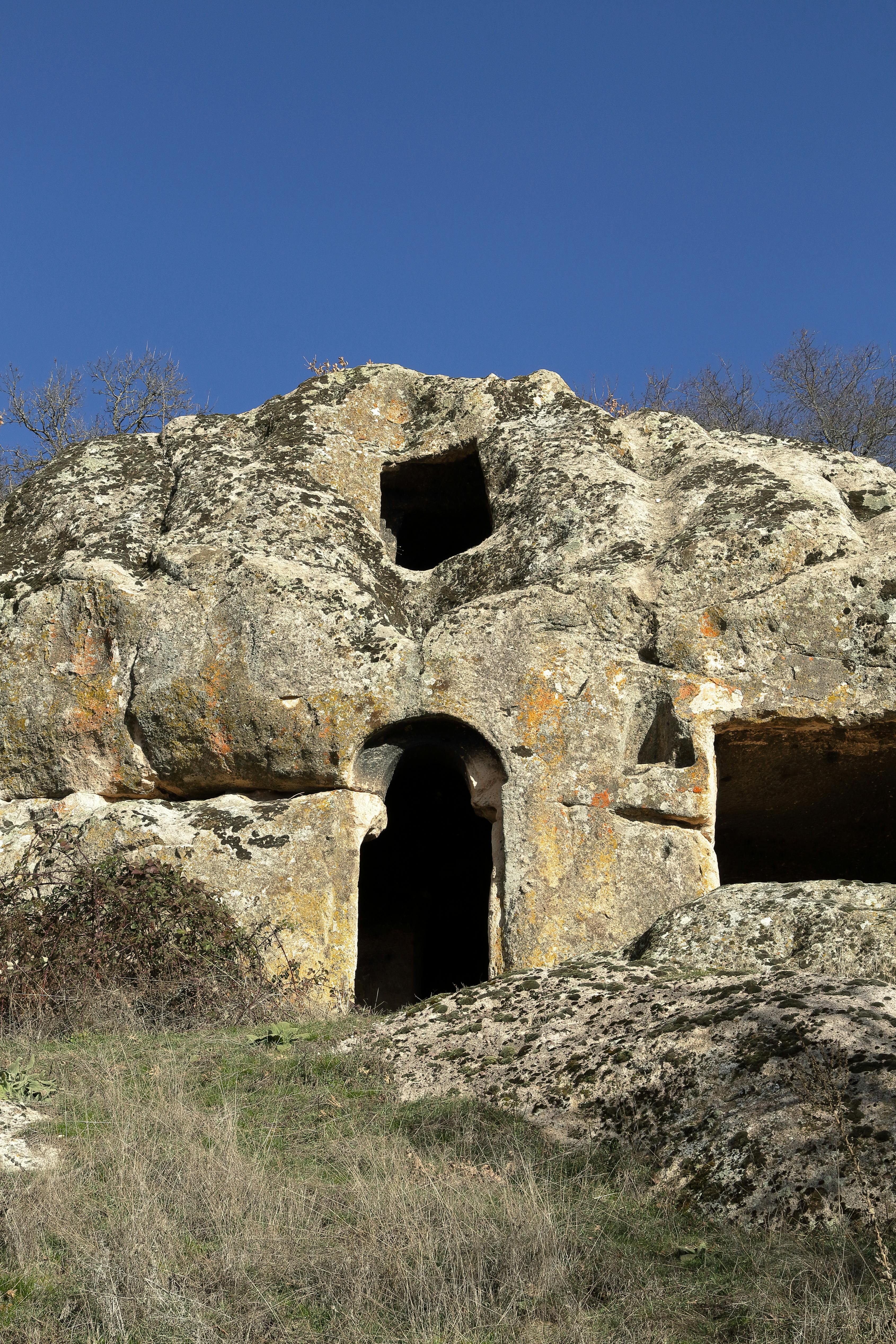 Ancient Rock-Cut Tombs in Rugged Landscape · Free Stock Photo