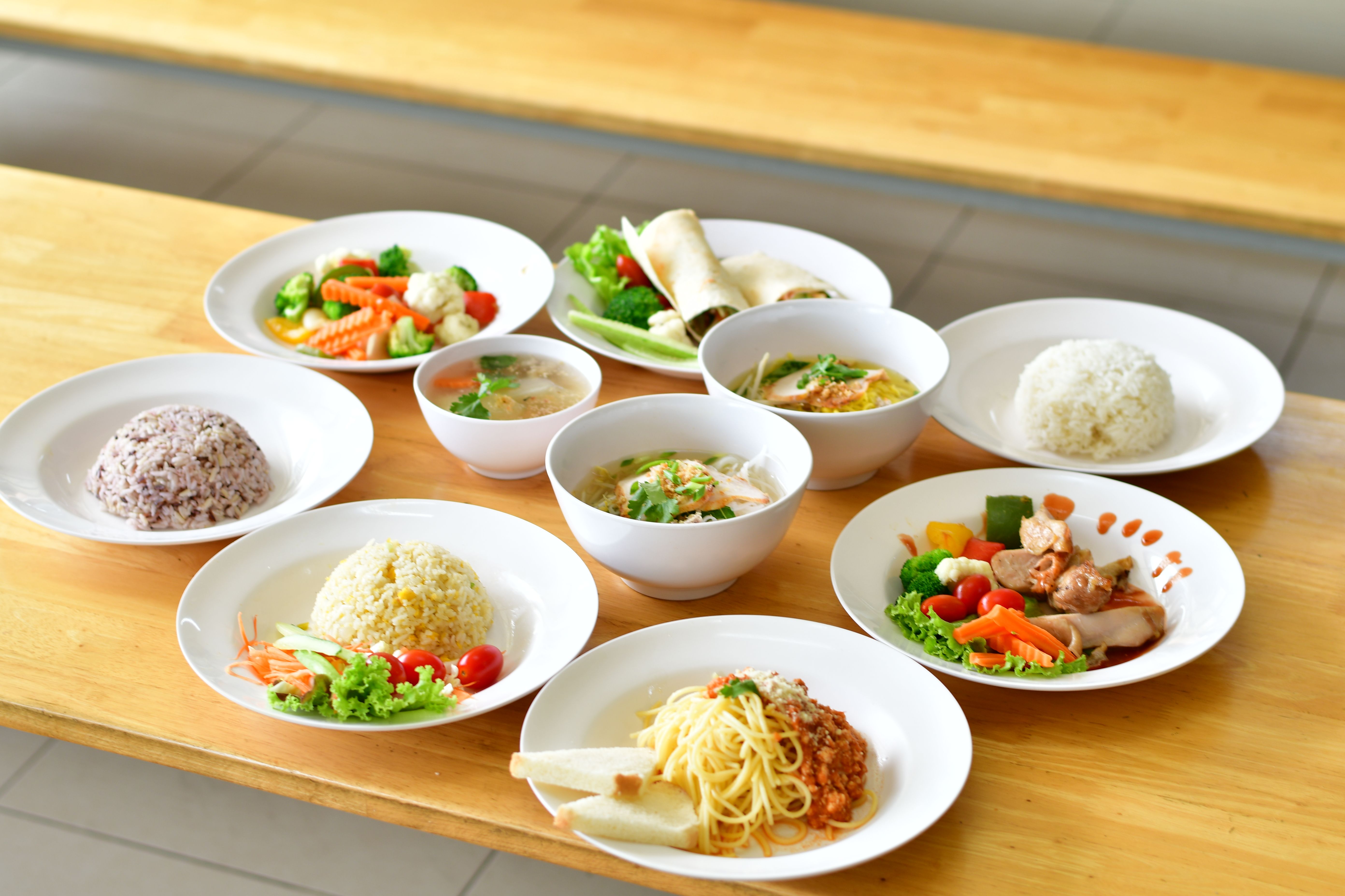 Assorted Asian and Italian Dishes on a Wooden Table · Free Stock Photo