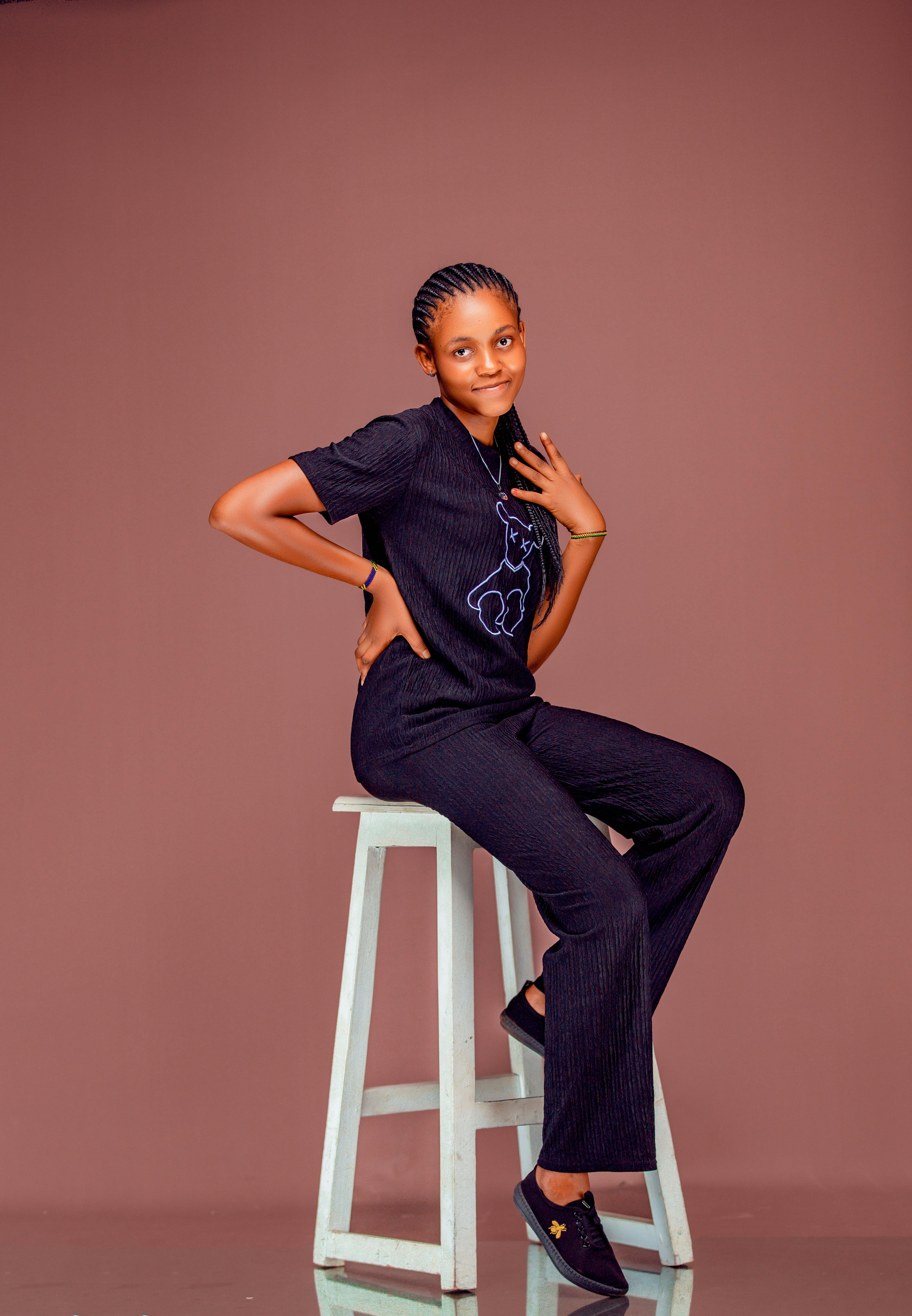 Confident Teenager Posing on Stool in Studio · Free Stock Photo