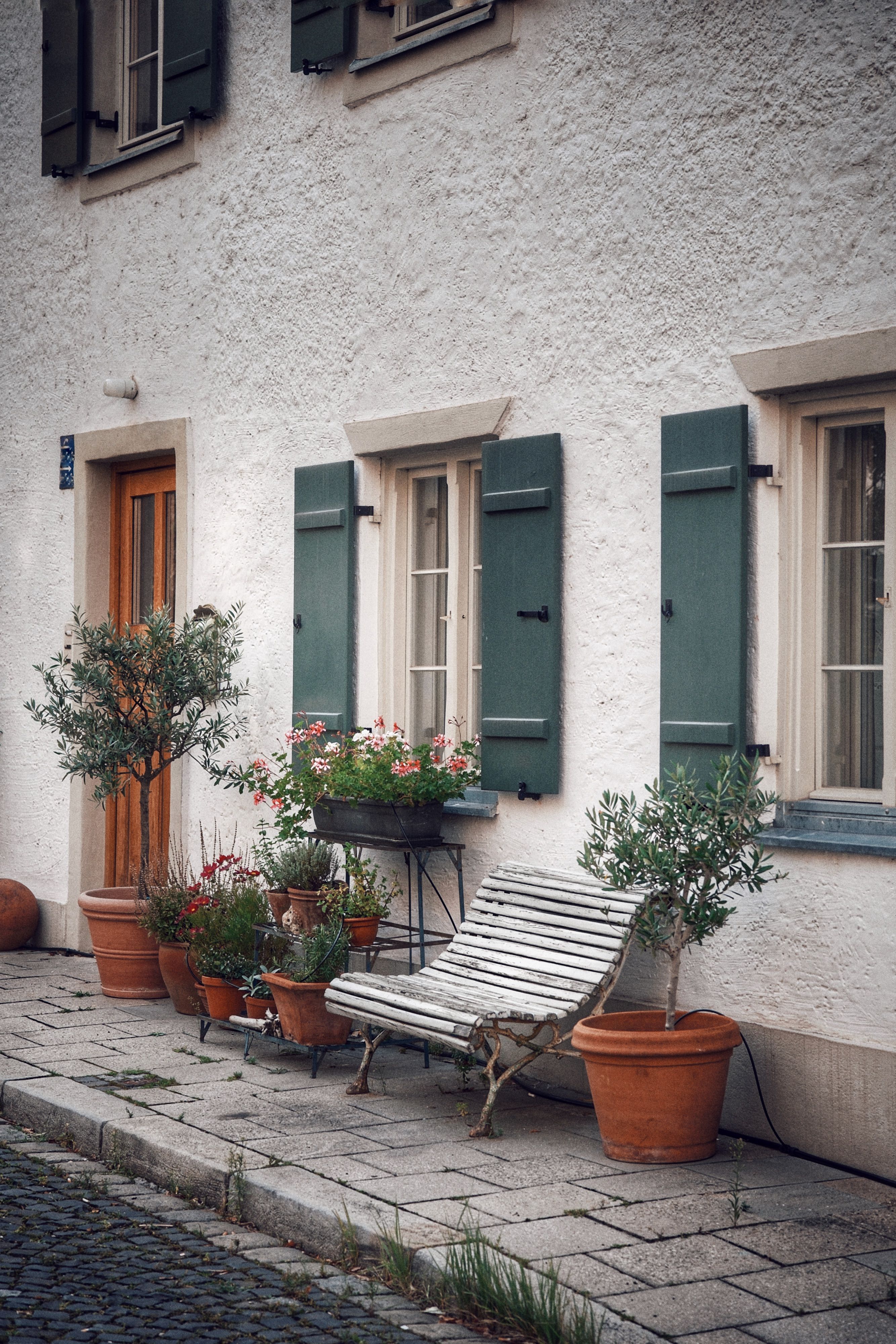 Charming European House Front with Potted Plants · Free Stock Photo
