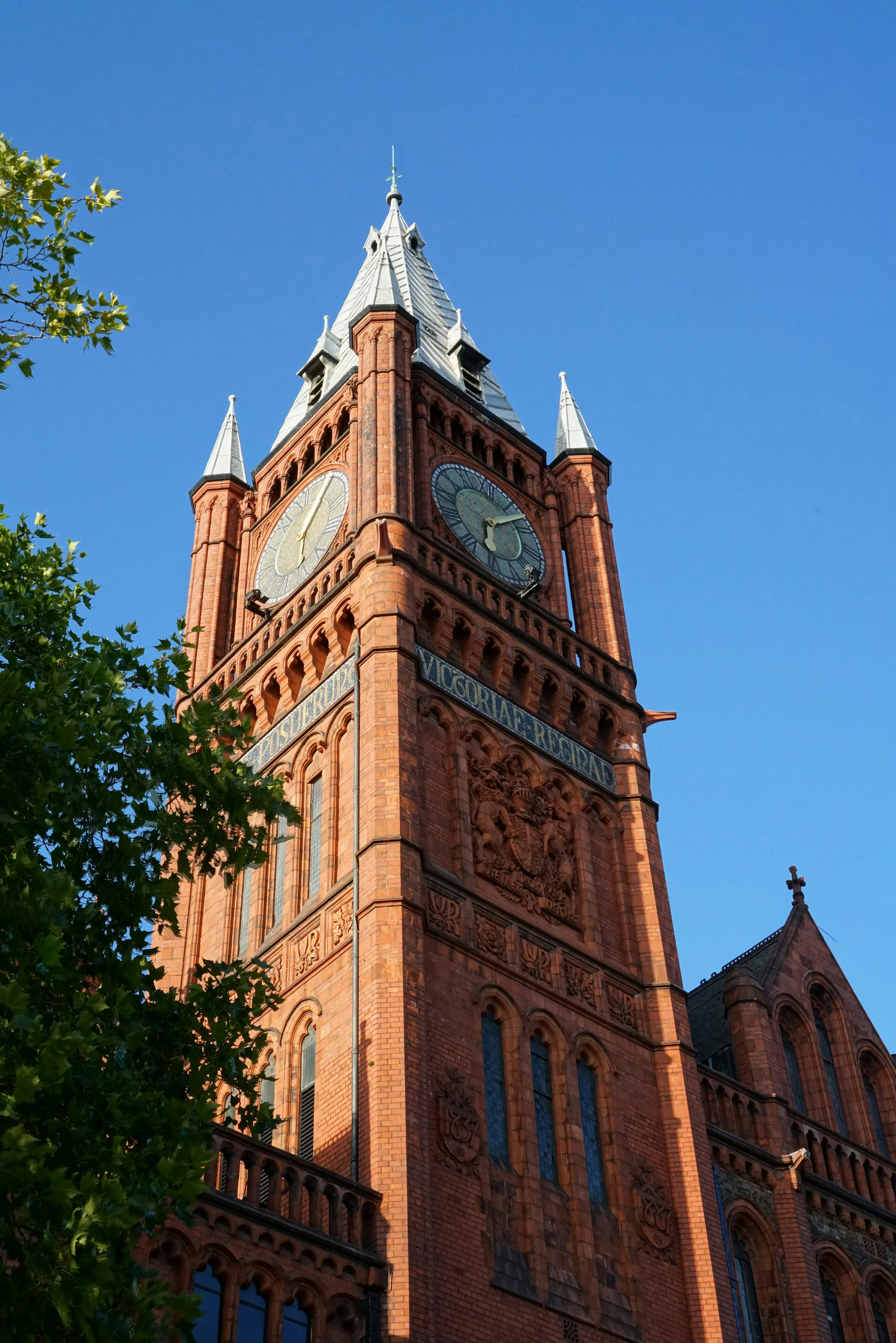 Historic Red Brick Clock Tower Against Blue Sky · Free Stock Photo