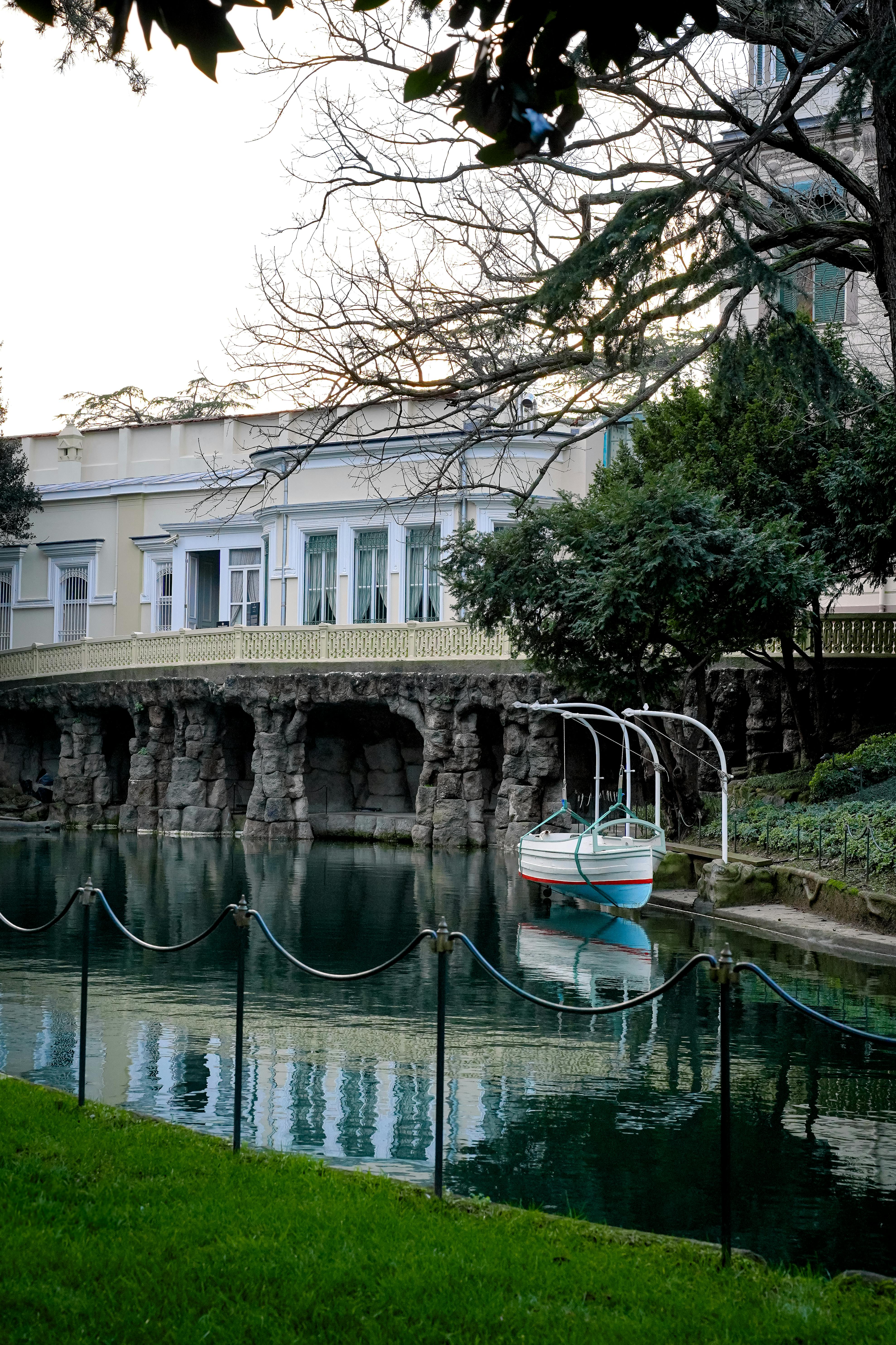 Tranquil Boat by Serene Waterside Building · Free Stock Photo