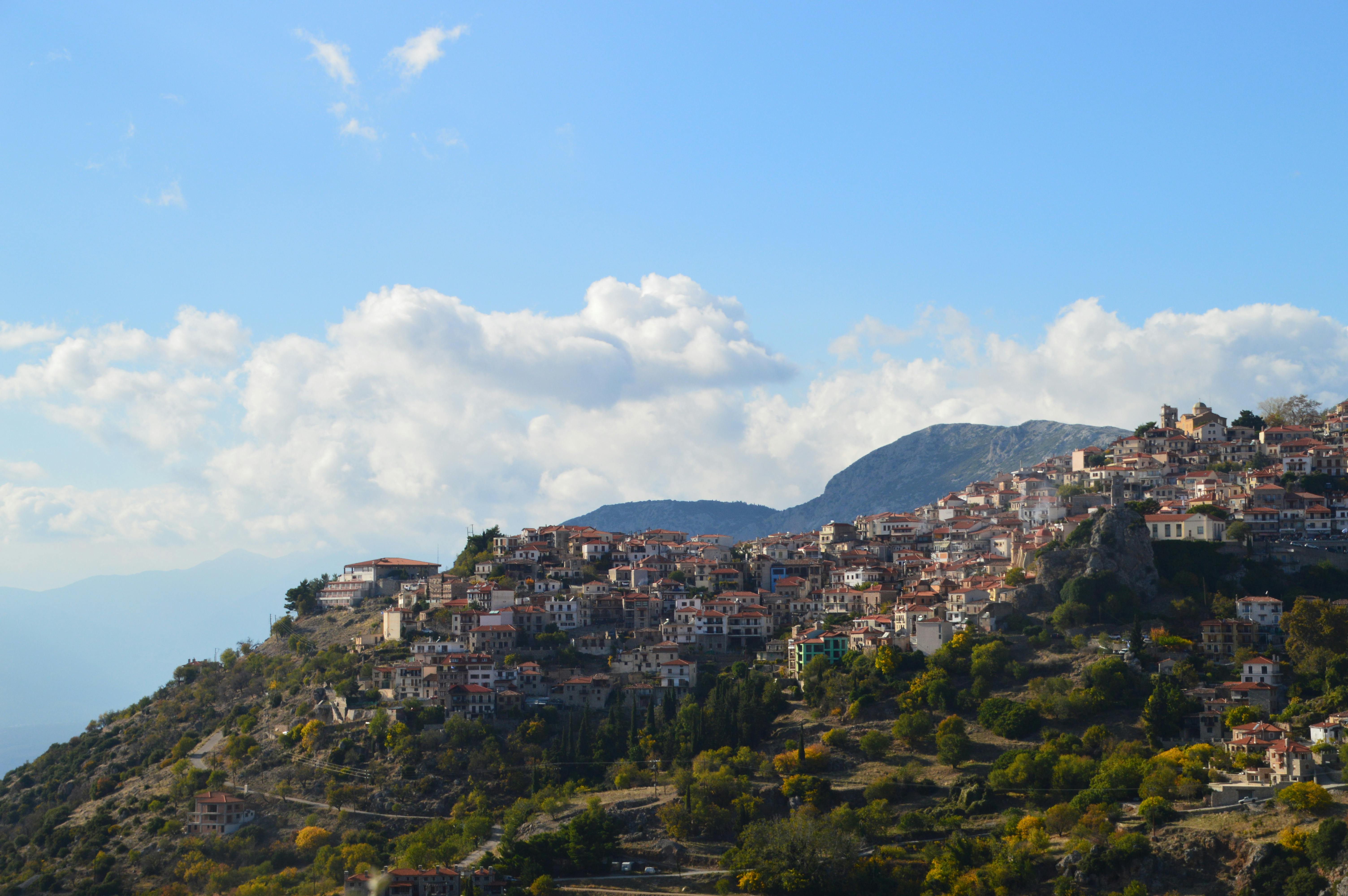 Scenic Greek Village on Hillside Under Clear Sky · Free Stock Photo