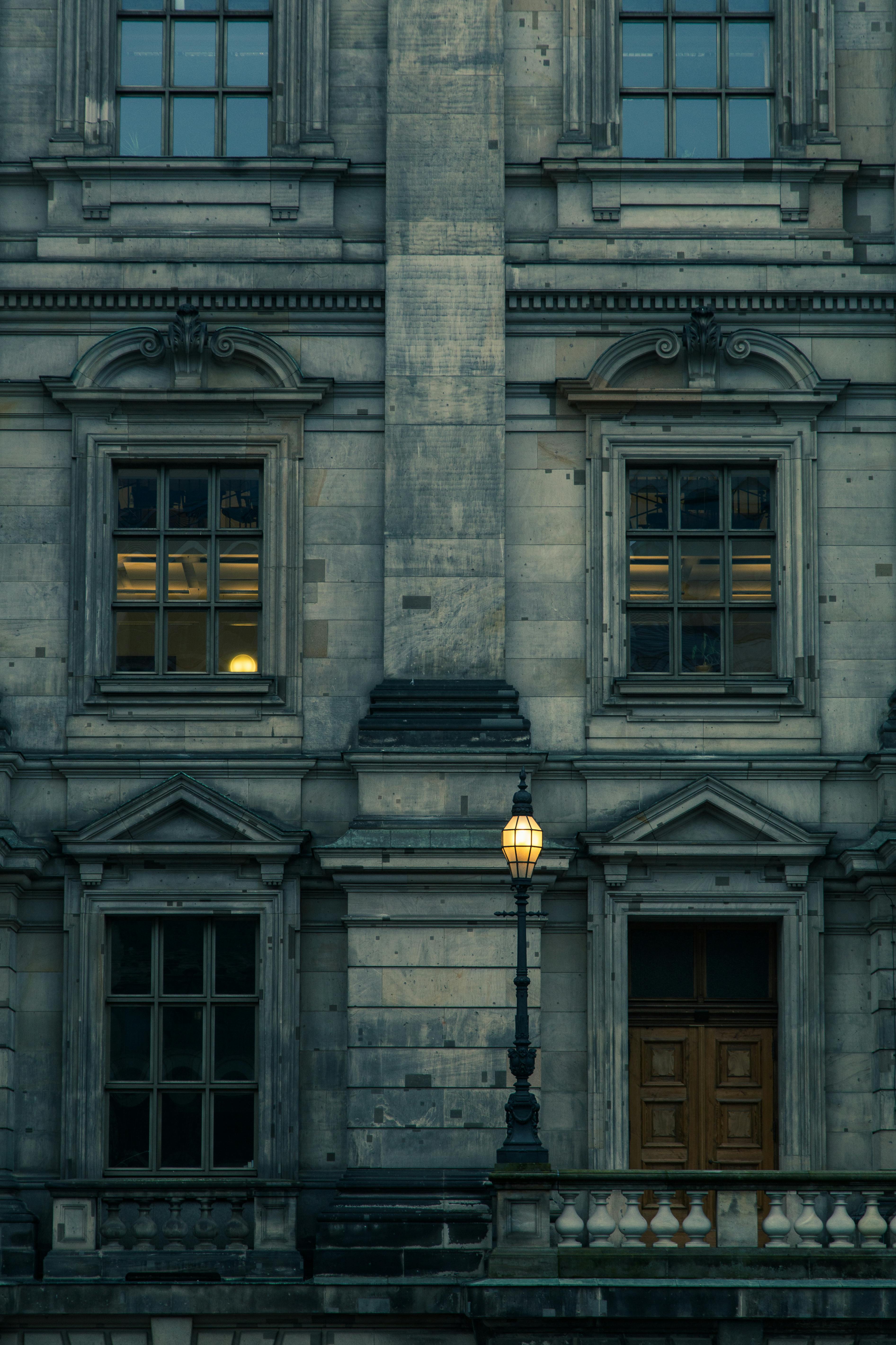 Classic Architectural Facade with Illuminated Streetlamp · Free Stock Photo