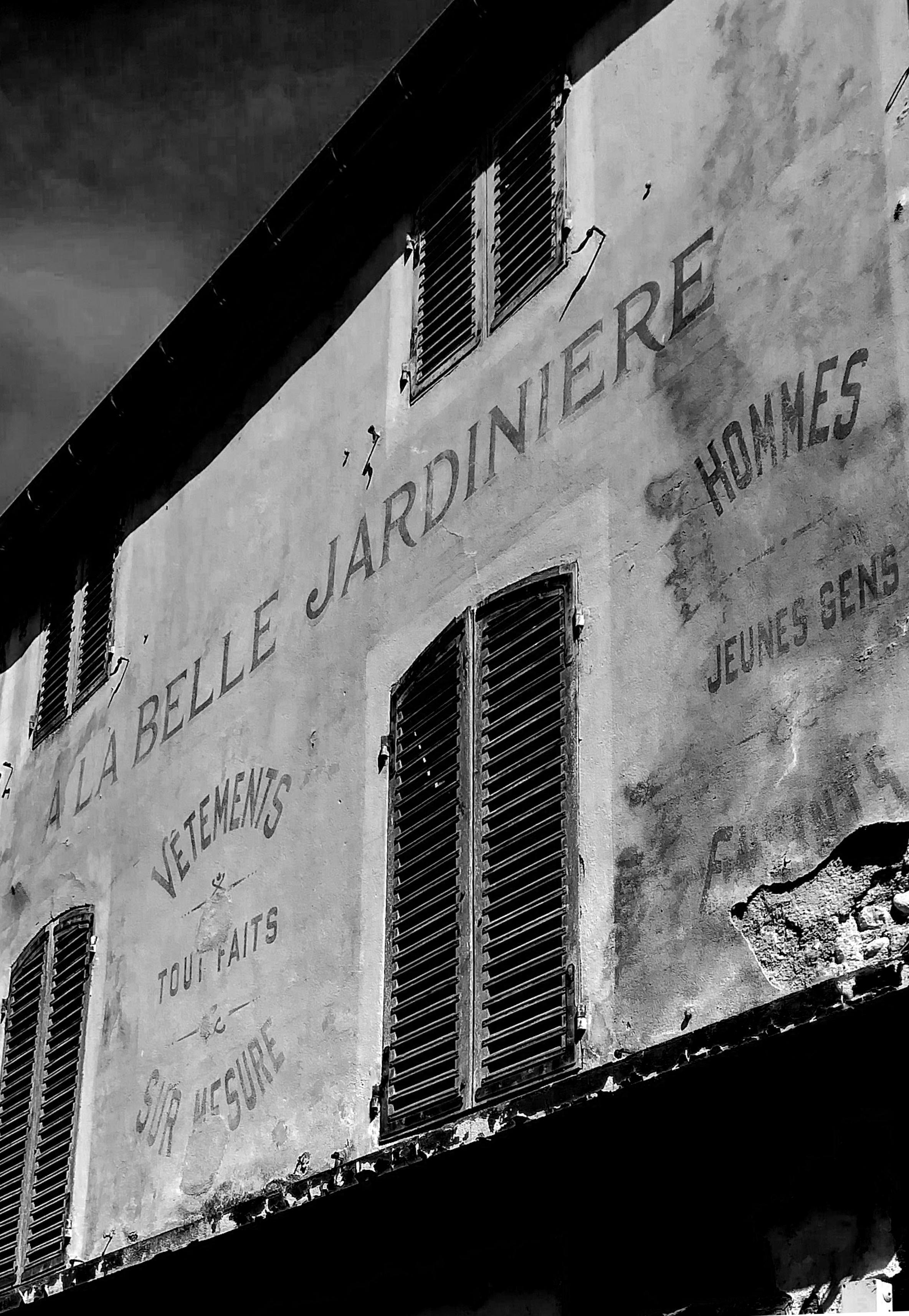Vintage French Shop Wall with Faded Signage · Free Stock Photo