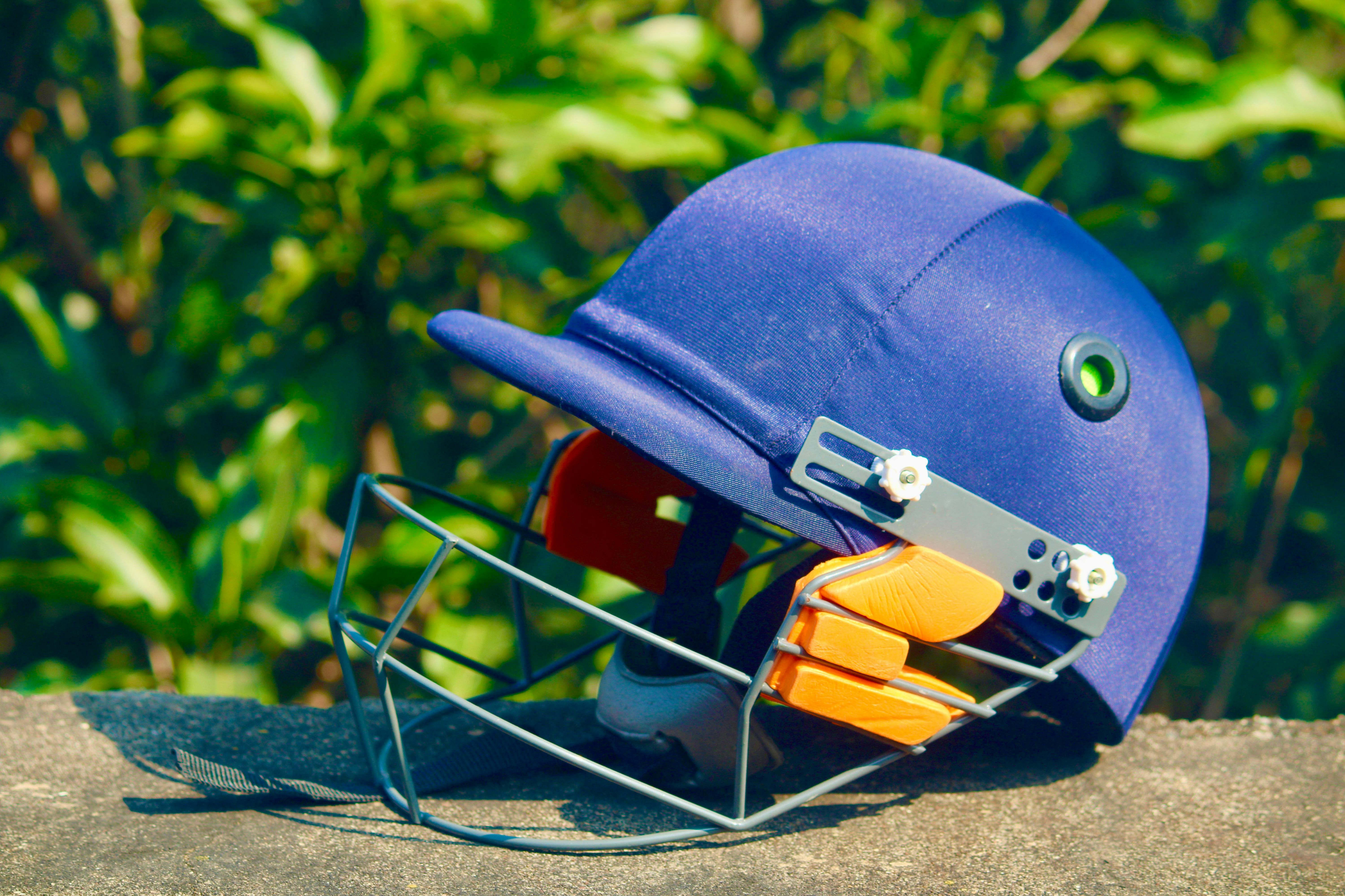 Blue Cricket Helmet on Stone Surface Outdoors · Free Stock Photo