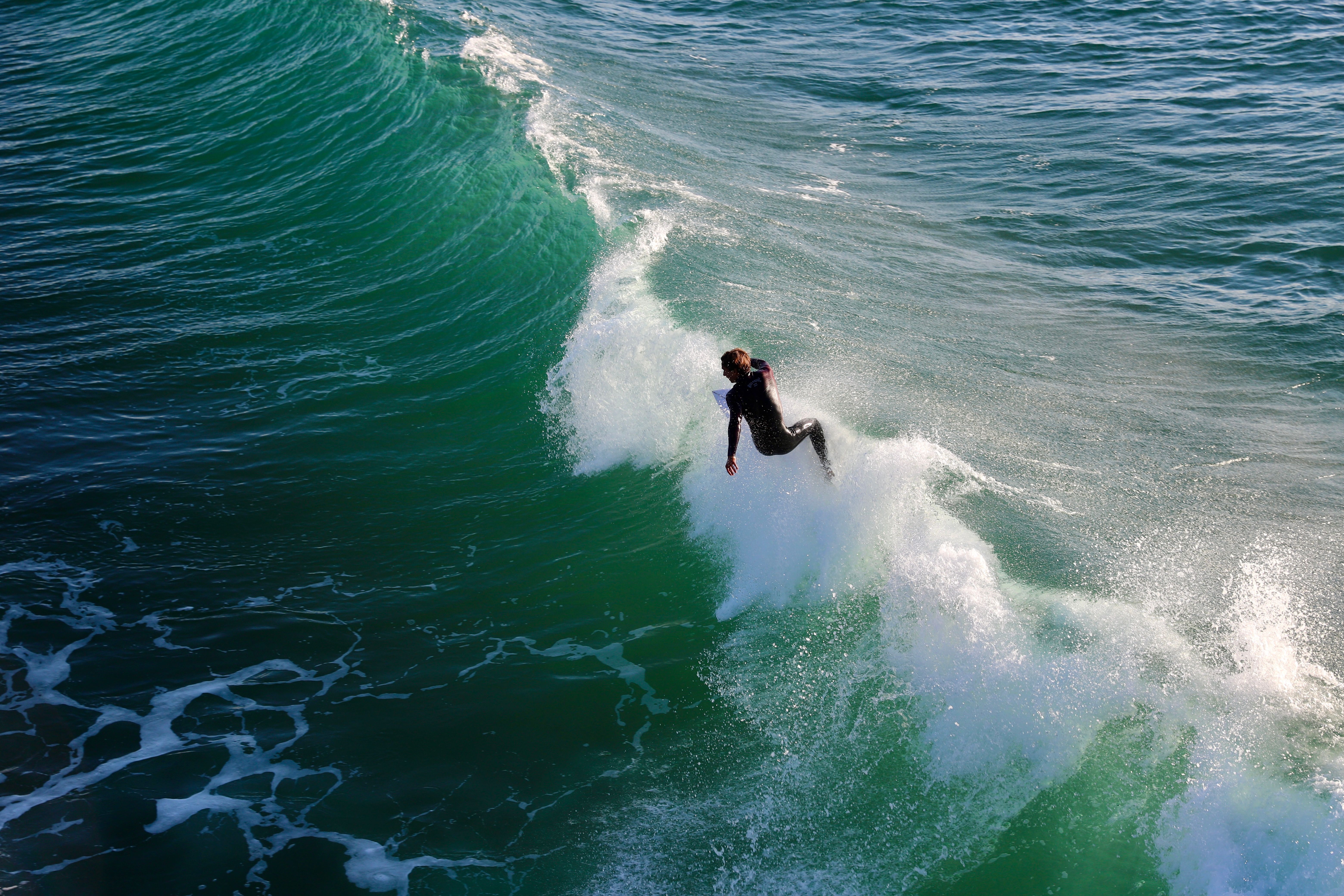 Surfer Riding a Powerful Ocean Wave in Daylight · Free Stock Photo
